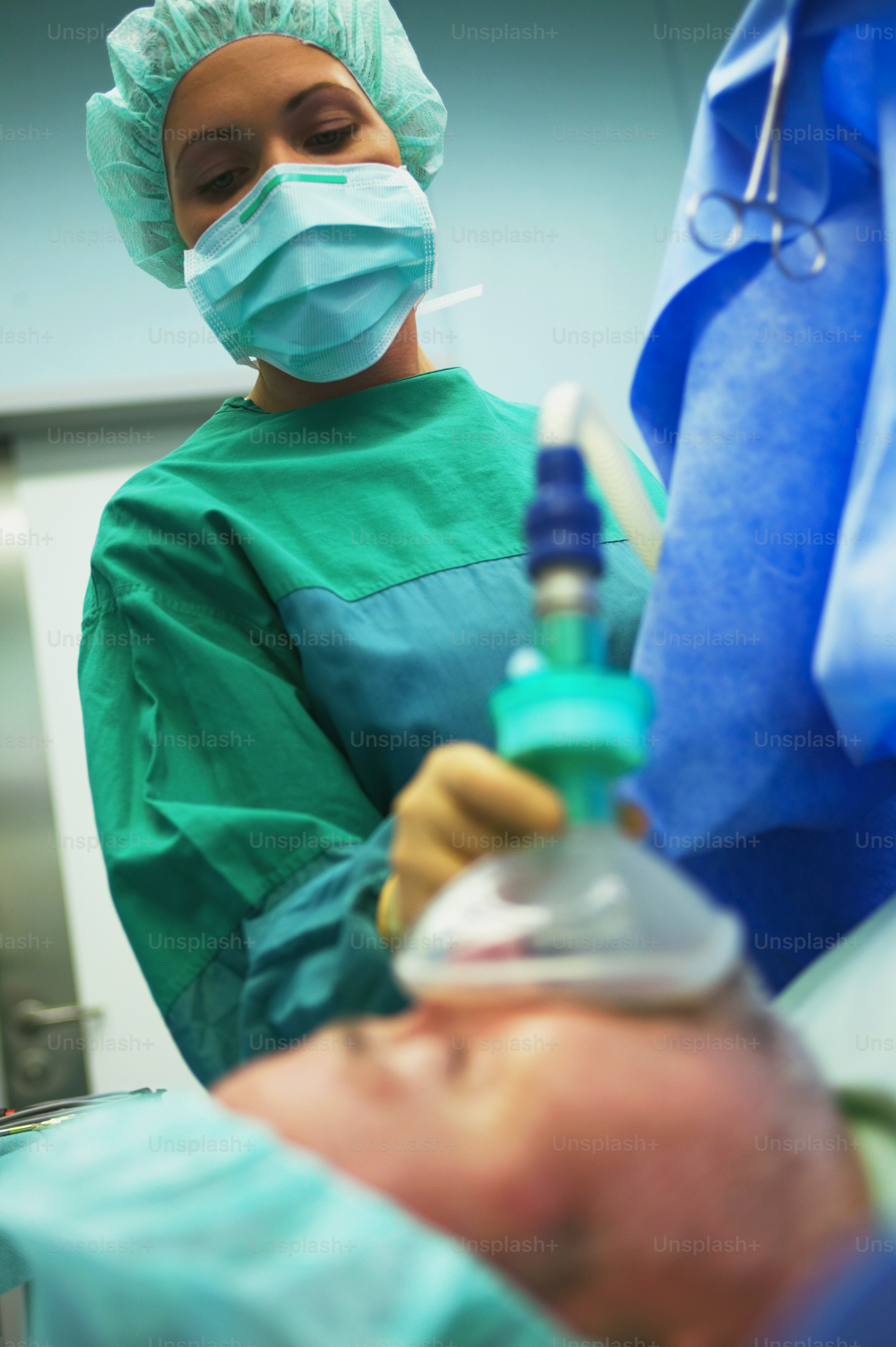 A person in a surgical gown and mask photo – Surgical mask Image on ...