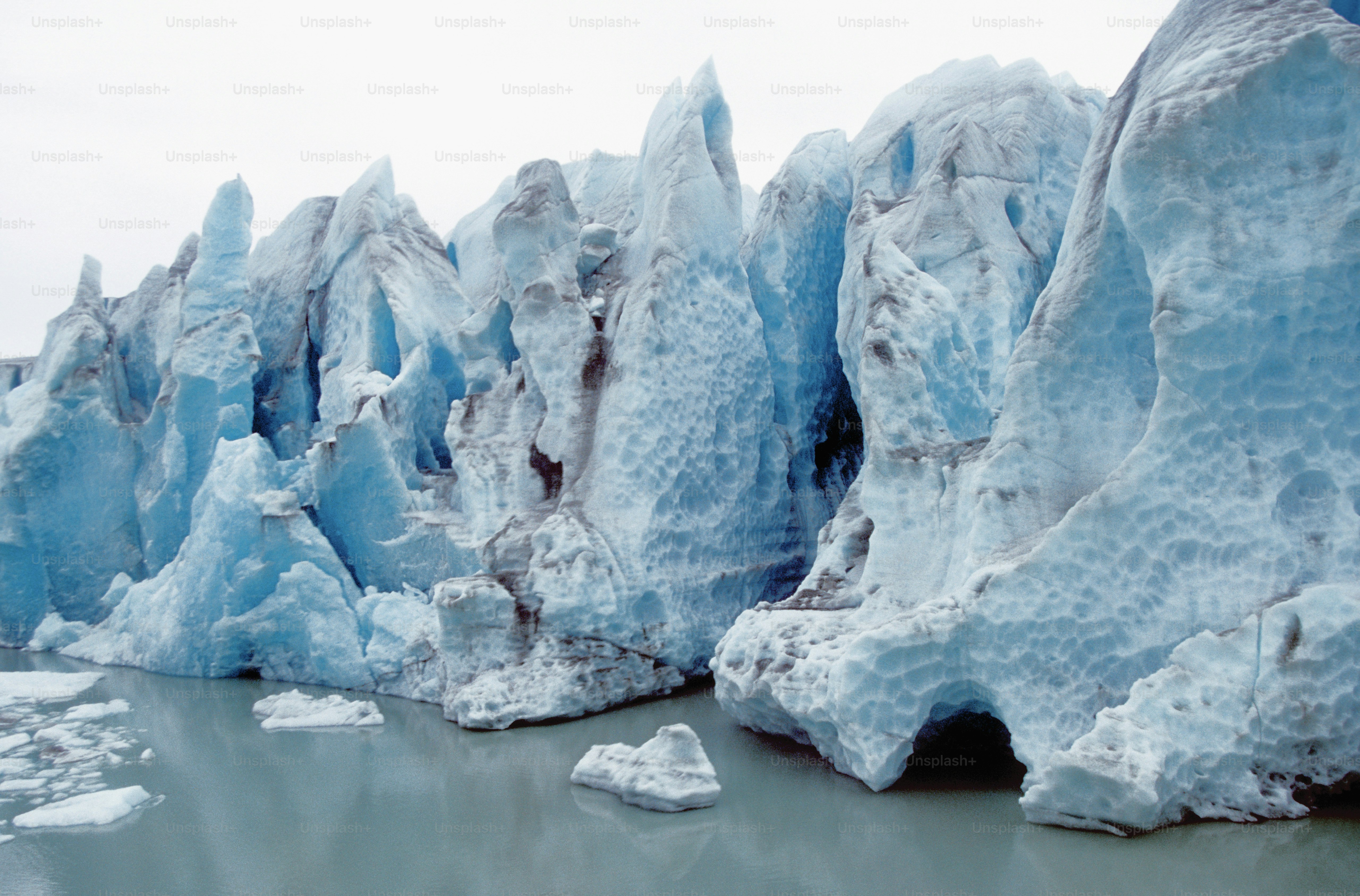 Un groupe de formations de glace à côté d’un plan d’eau photo – La ...
