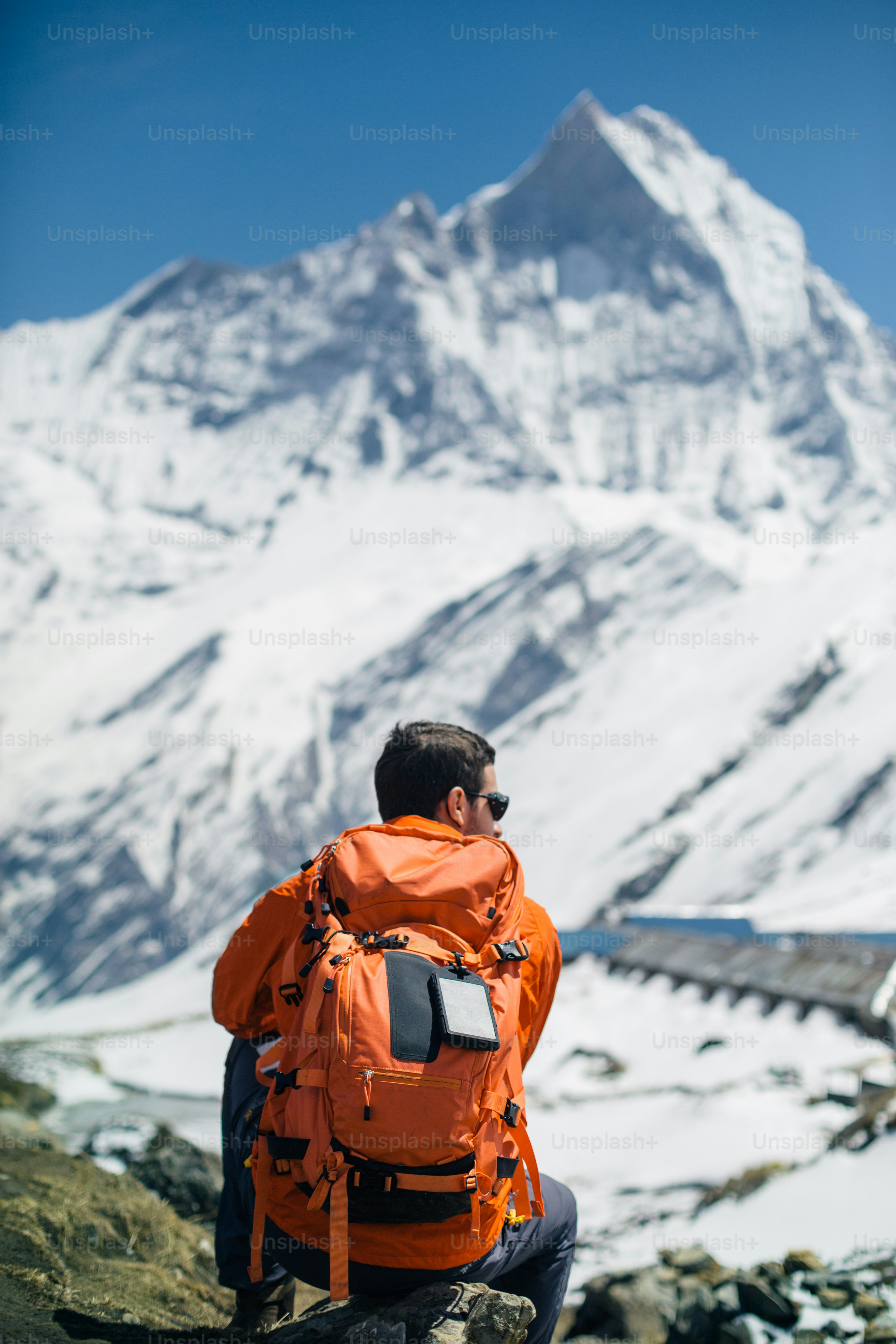 Hiker sitting below the summit of Machapuchare (6993m). Machhapuchre is ...