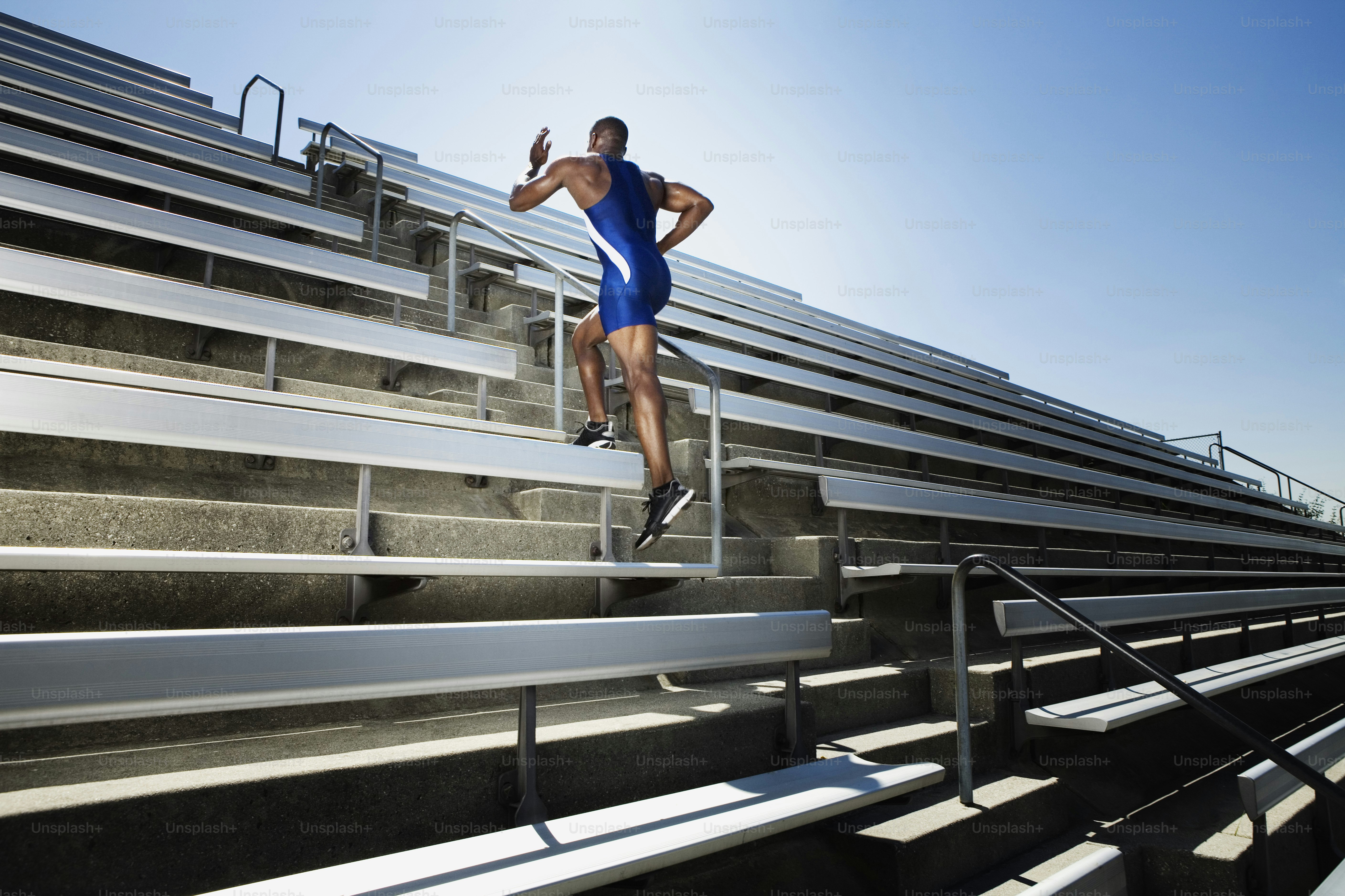 Un hombre en traje de baño azul corre por un conjunto de gradas foto ...