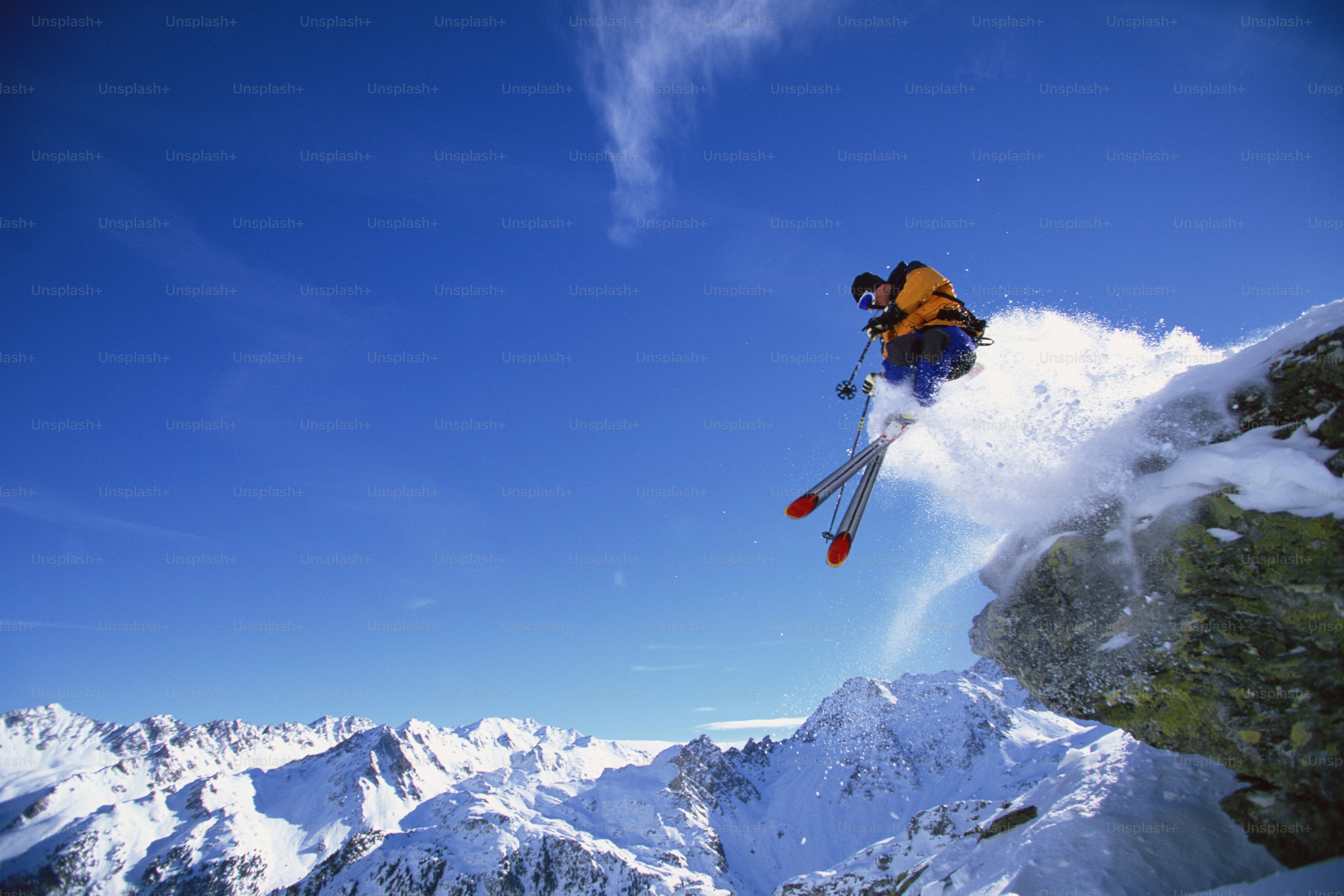 A man flying through the air while riding skis photo – Skiing Image on ...