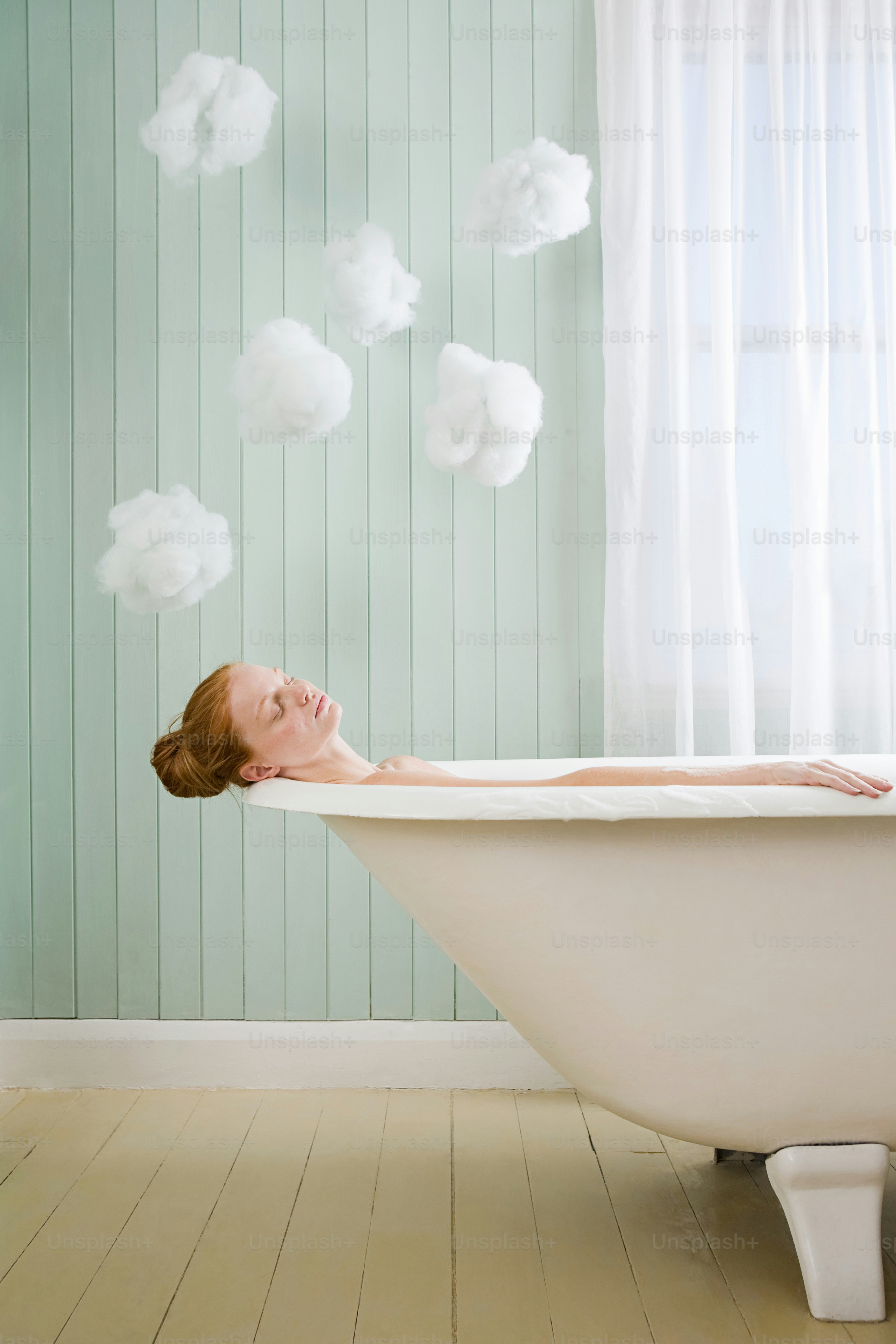 A woman laying down in a bathtub in a bathroom photo – Eyes closed ...