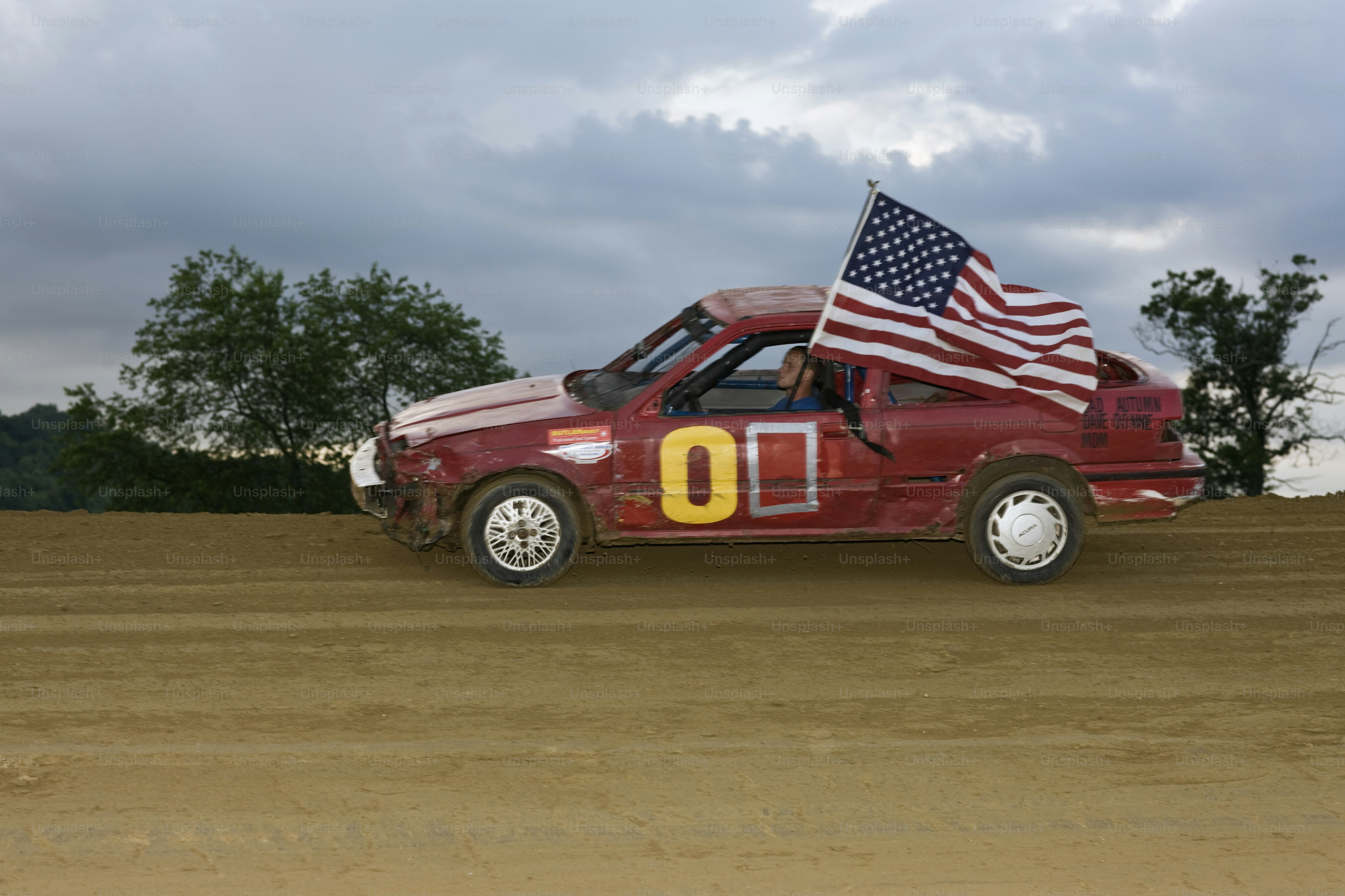Race car taking a lap around the racetrack with the American Flag ...