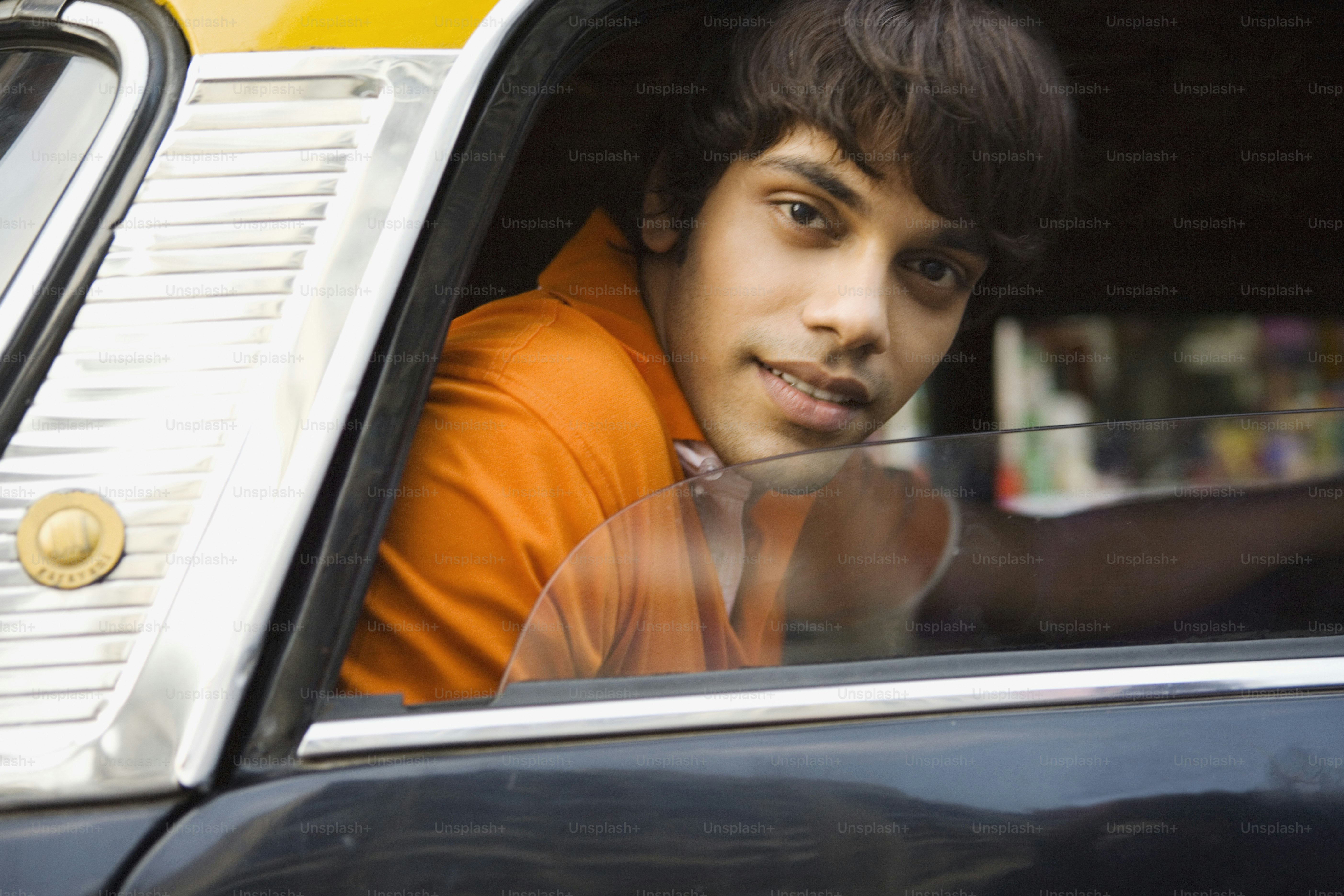 A man sitting in a car looking out the window photo – Car Image on Unsplash