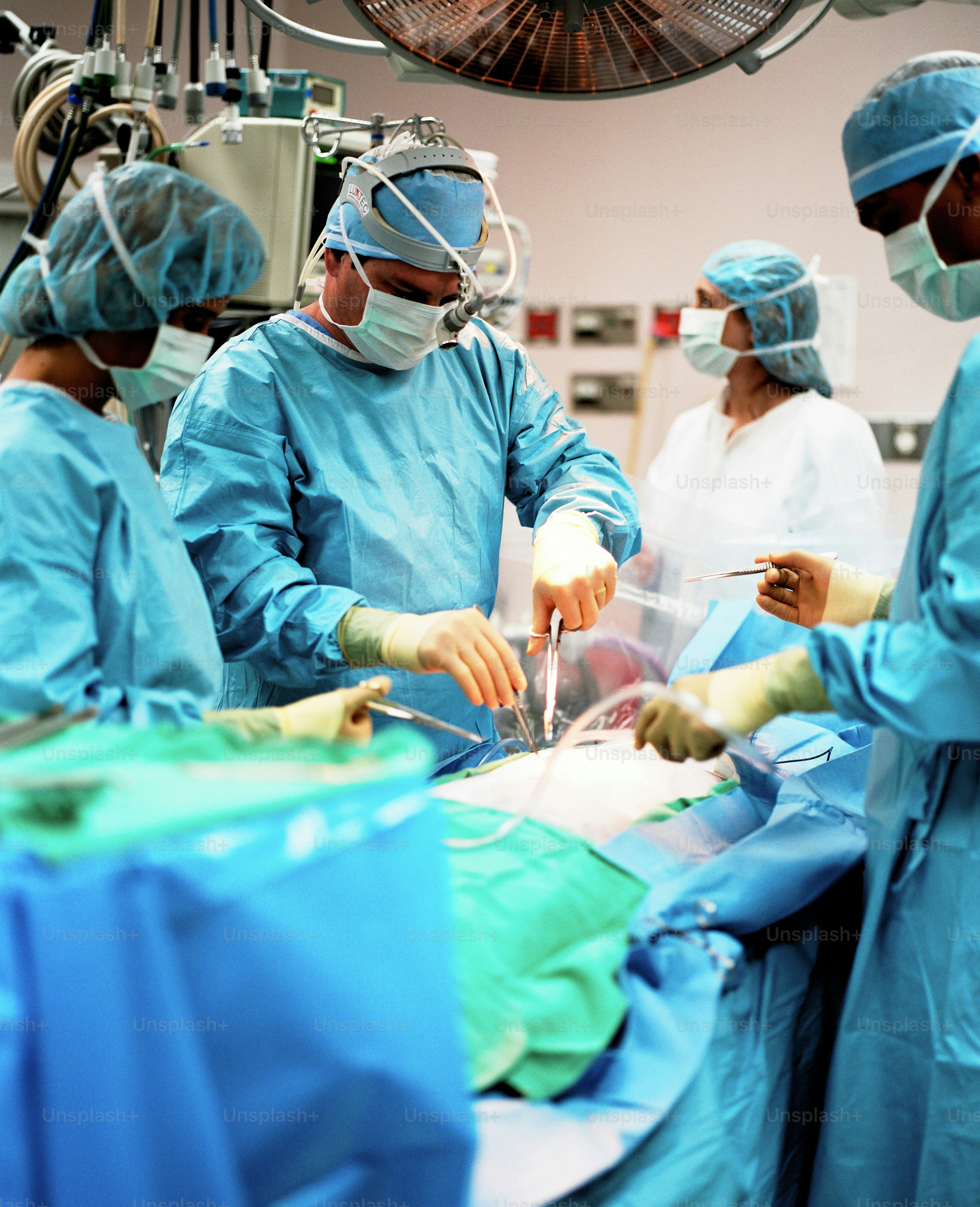 A group of doctors performing surgery in a hospital photo – Hospital ...