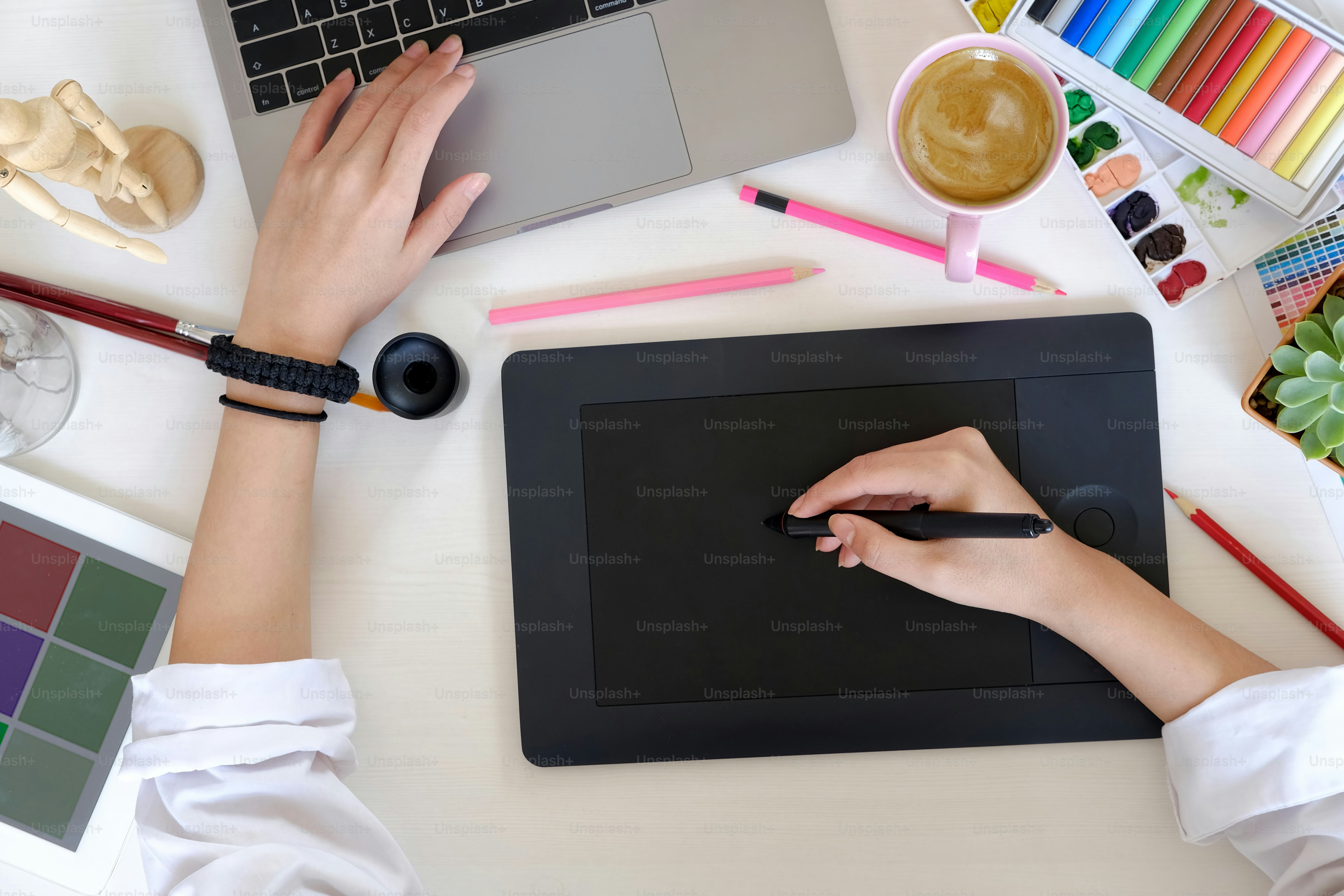 Young female designer using graphics tablet while working with computer ...