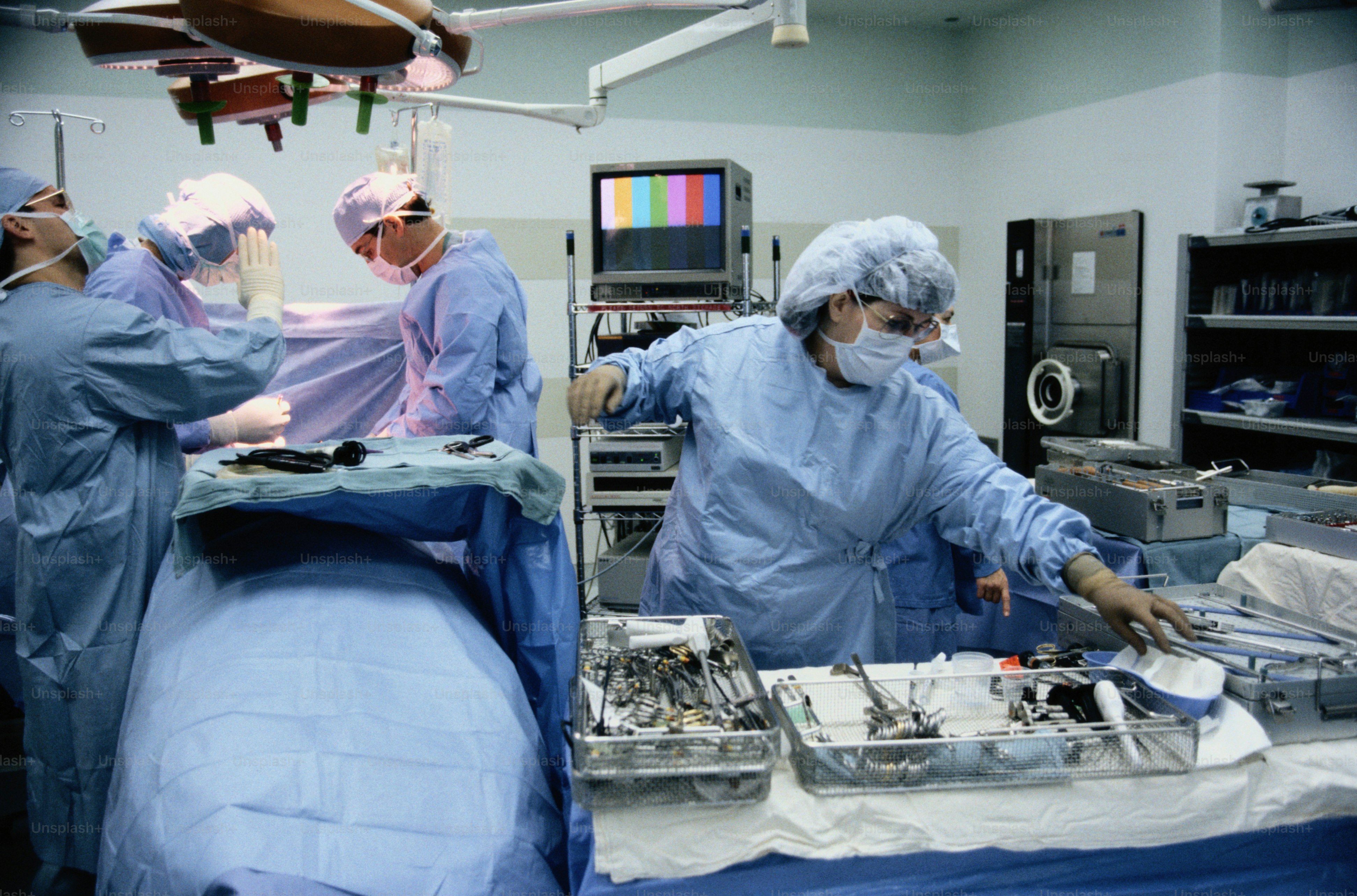 A group of doctors performing surgery in a hospital photo – Hospital ...