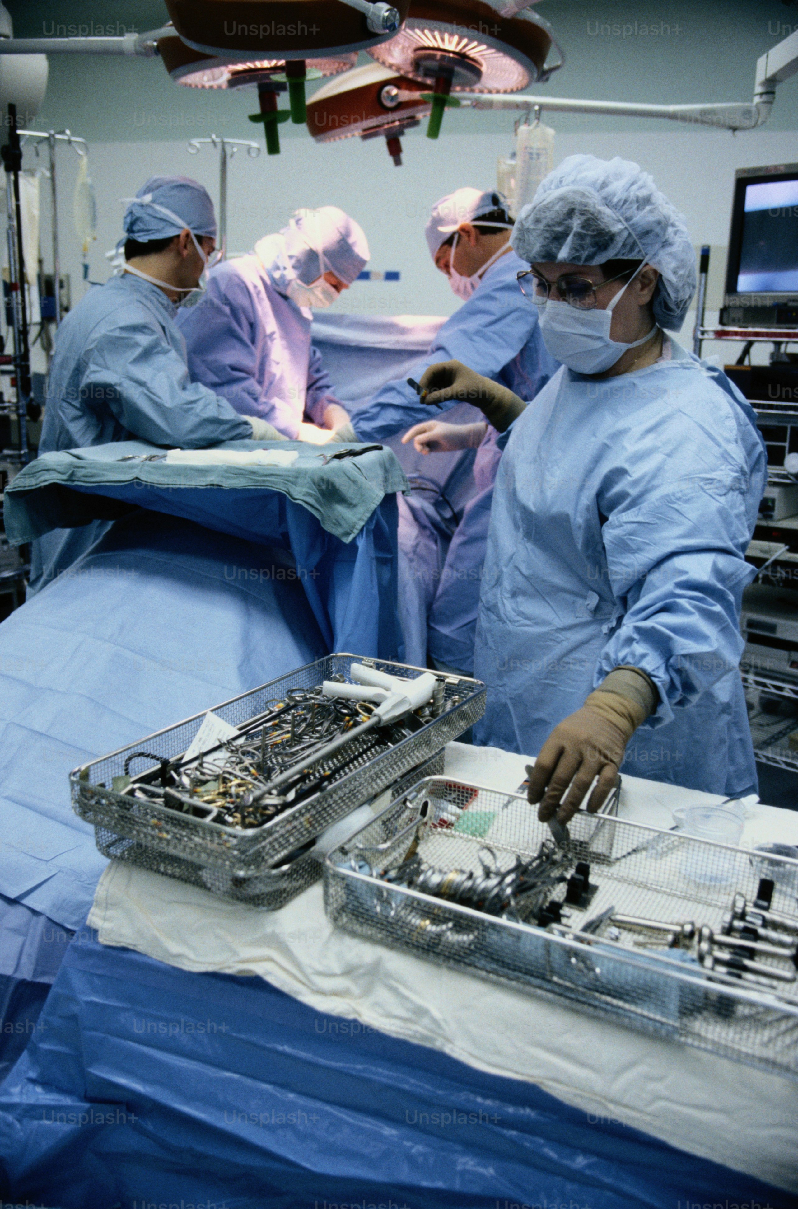 A group of doctors performing surgery in a hospital photo – People ...