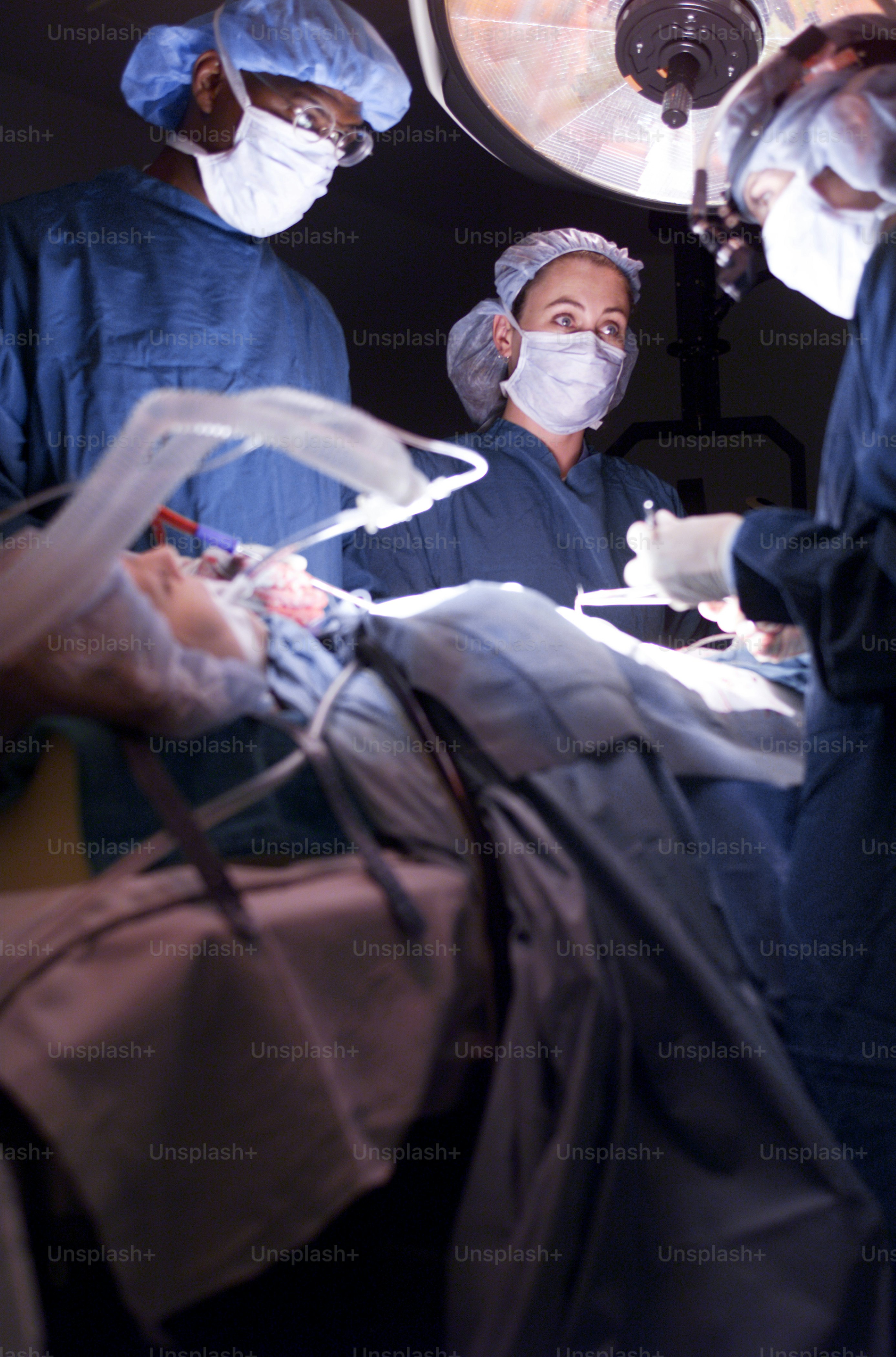 Foto zum Thema Eine Gruppe von Ärzten, die einen Patienten operieren ...