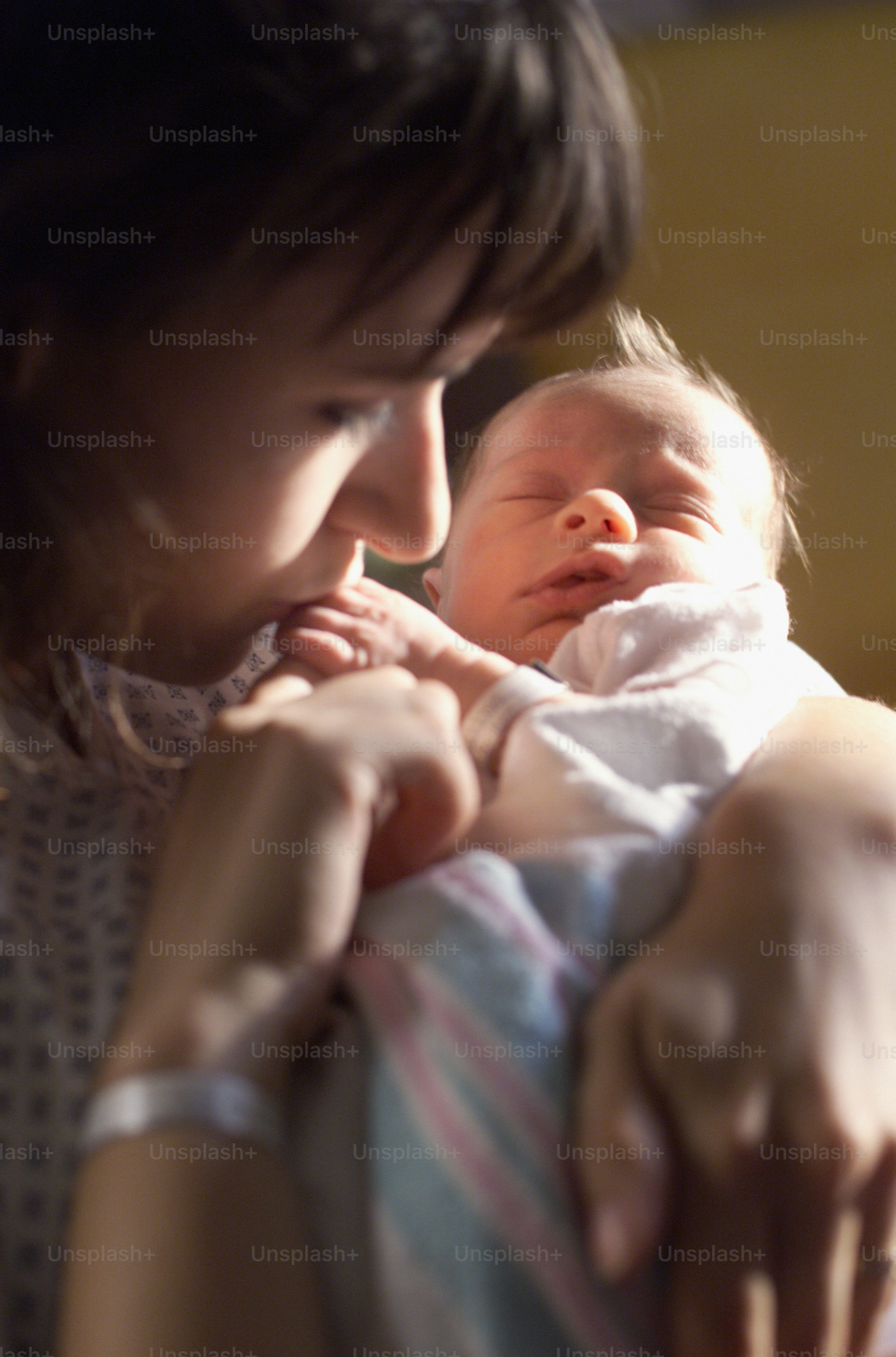 Une femme tenant un bébé dans ses bras photo – Nouveau née Photo sur ...