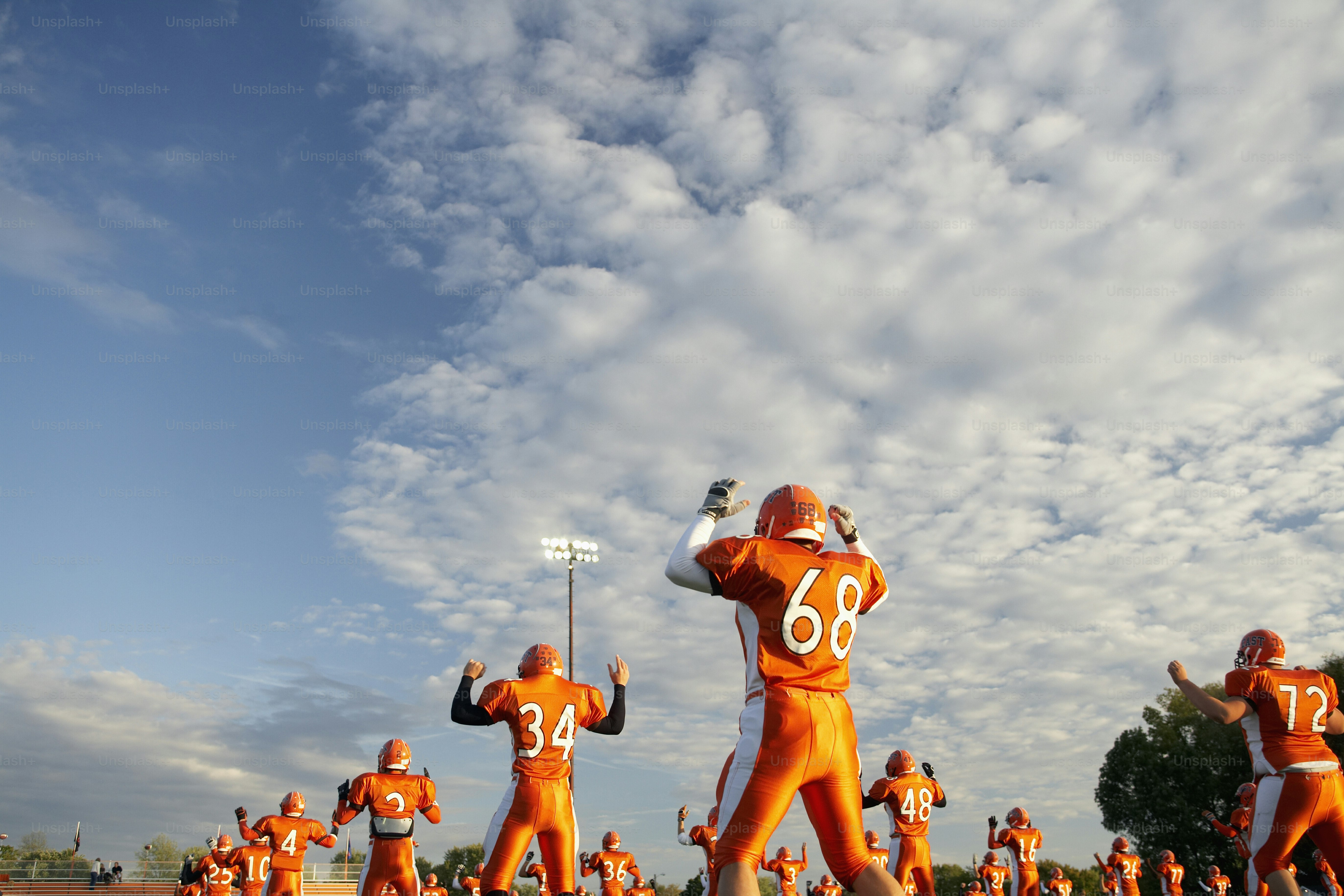 A group of football players standing on top of a field photo ...