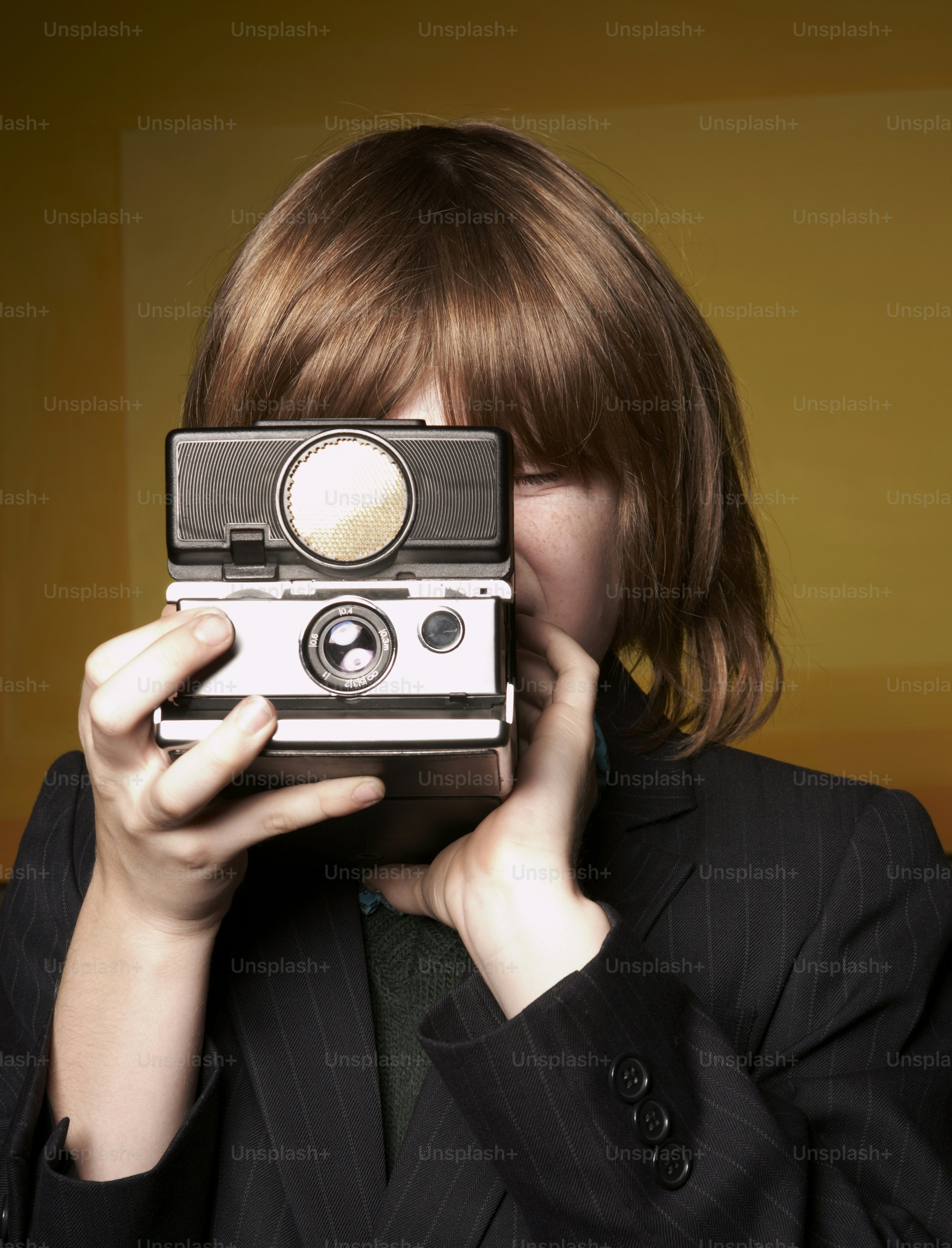 A person holding a camera up to their face photo – Photograph Image on ...