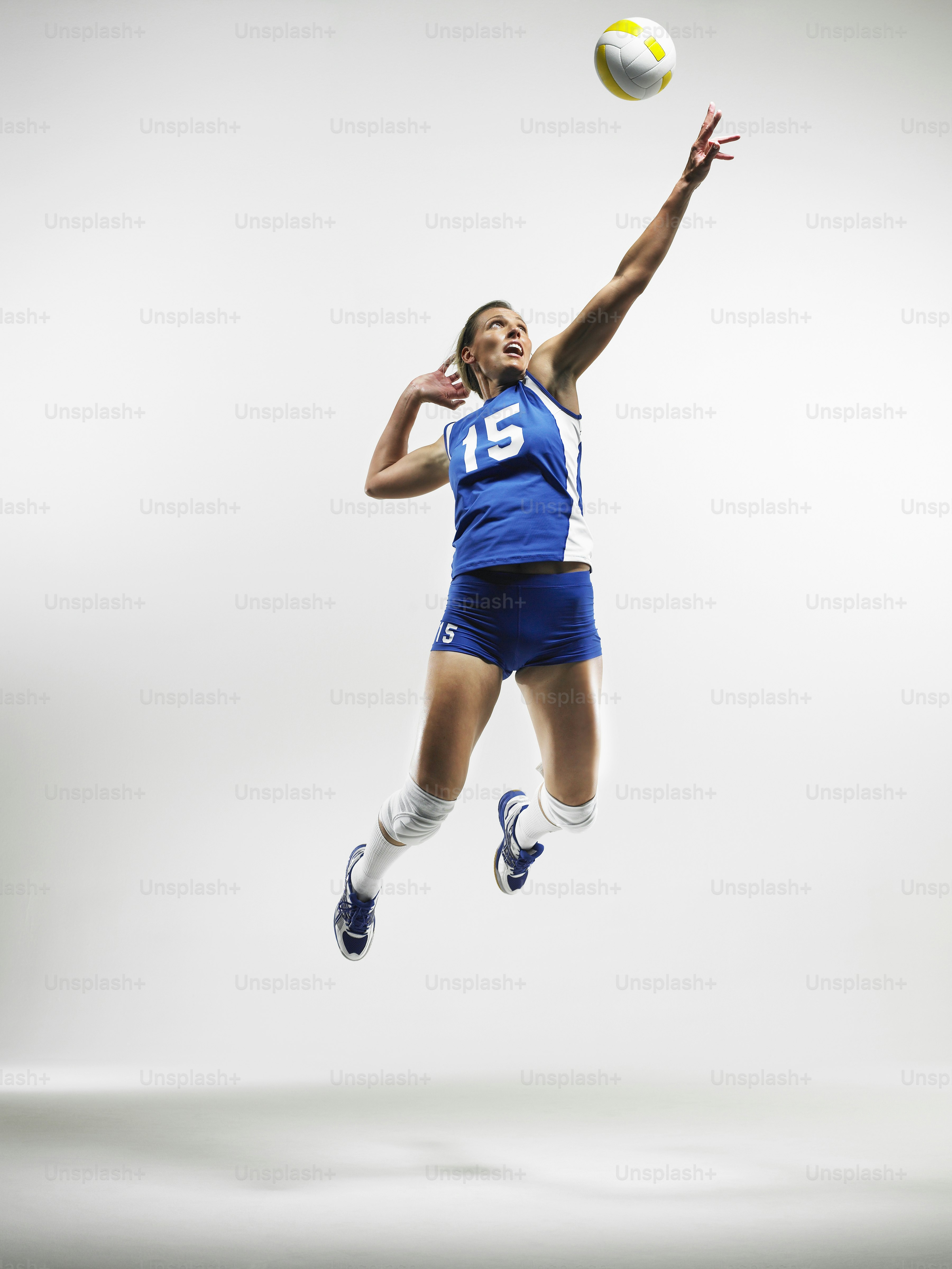 A woman jumping in the air to catch a volleyball photo – Volleyball ...