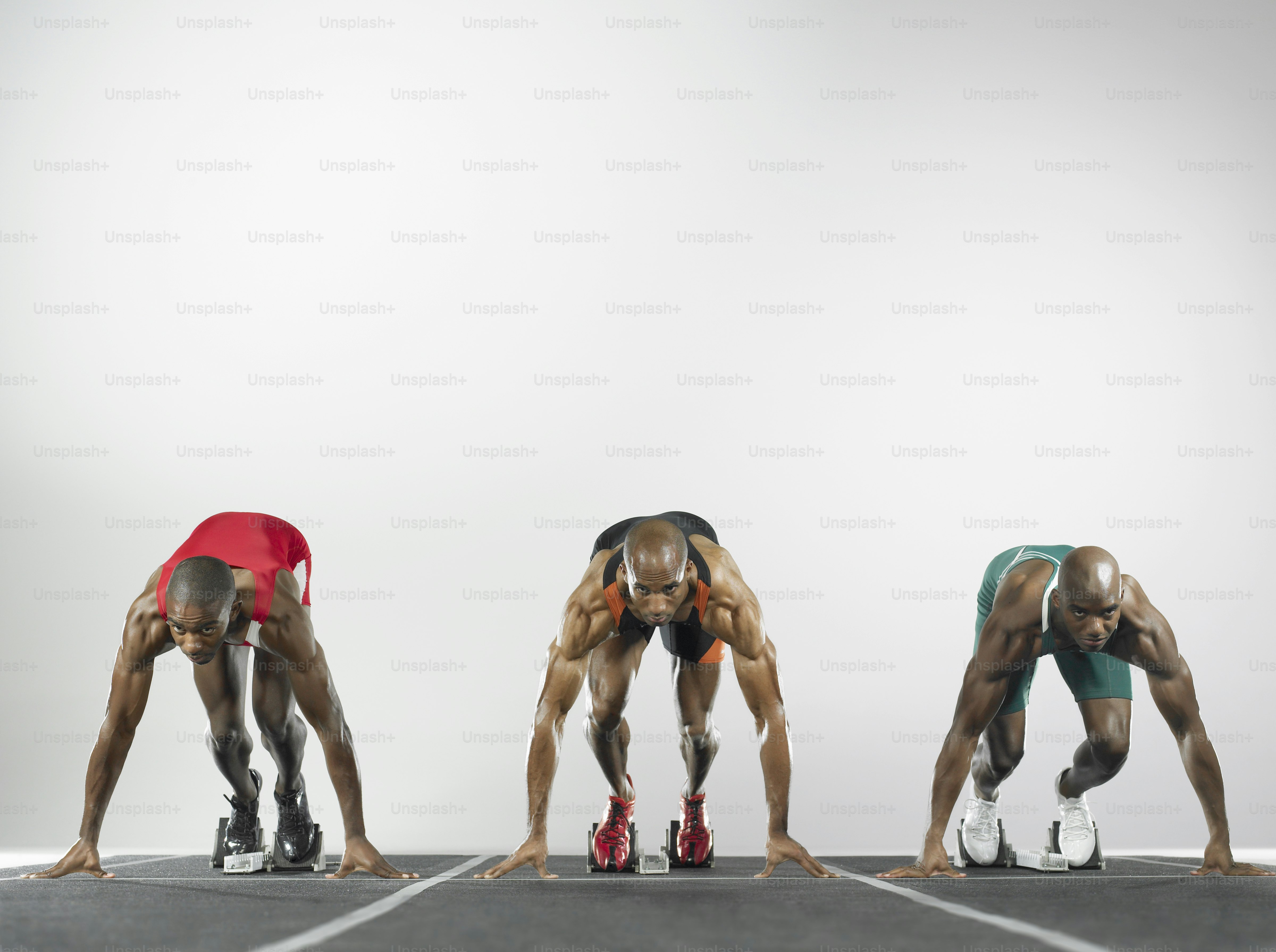 A group of three men standing on top of a race track photo – Start line ...