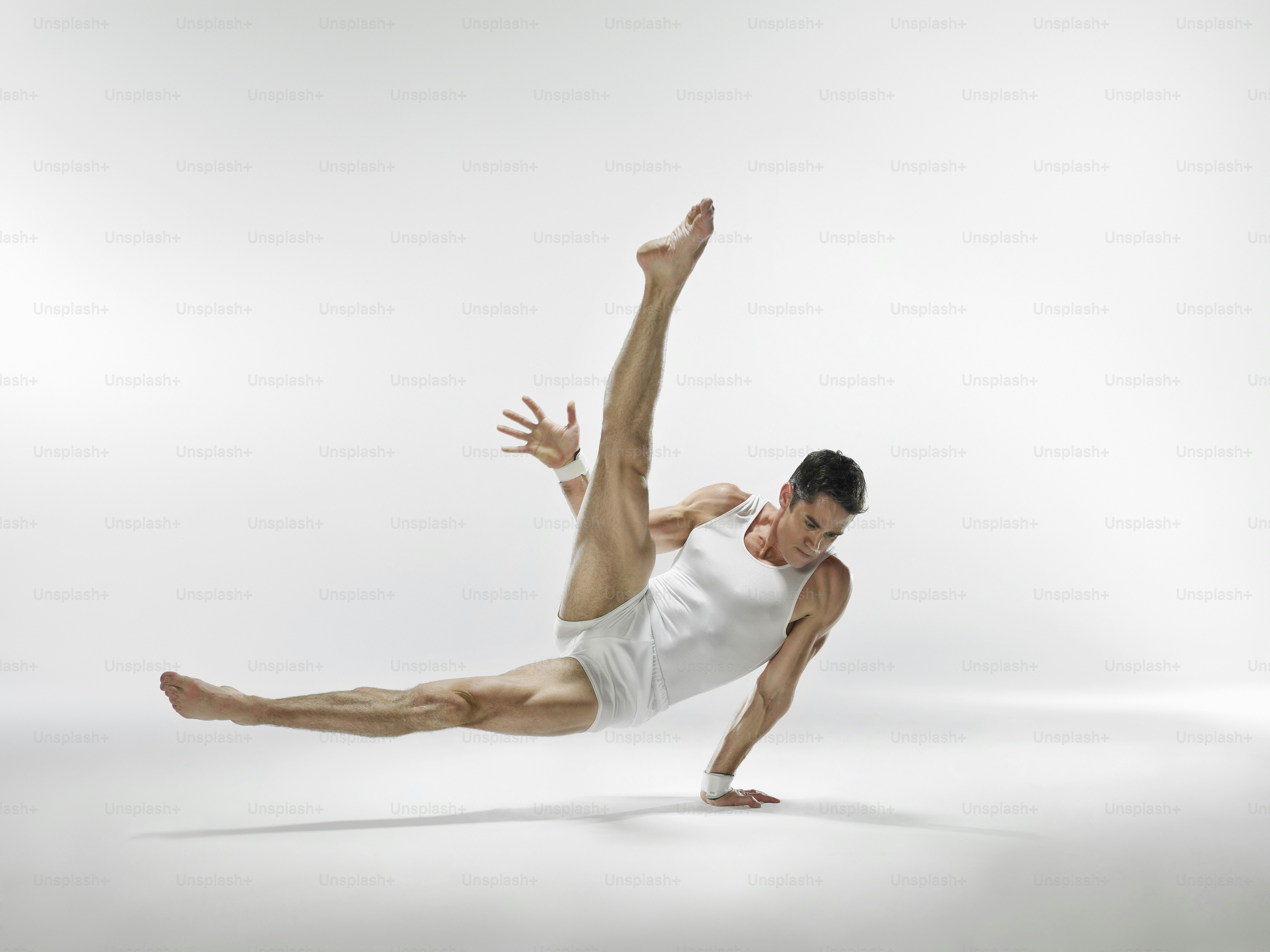 A man in white shirt and shorts doing a dance pose photo – One mid ...