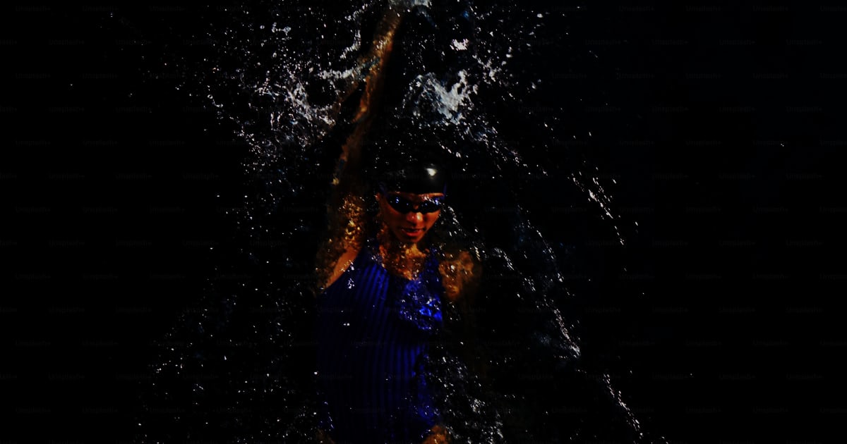 青い水着を着た女性が水の中を泳いでいるの写真 水 Unsplashの写真