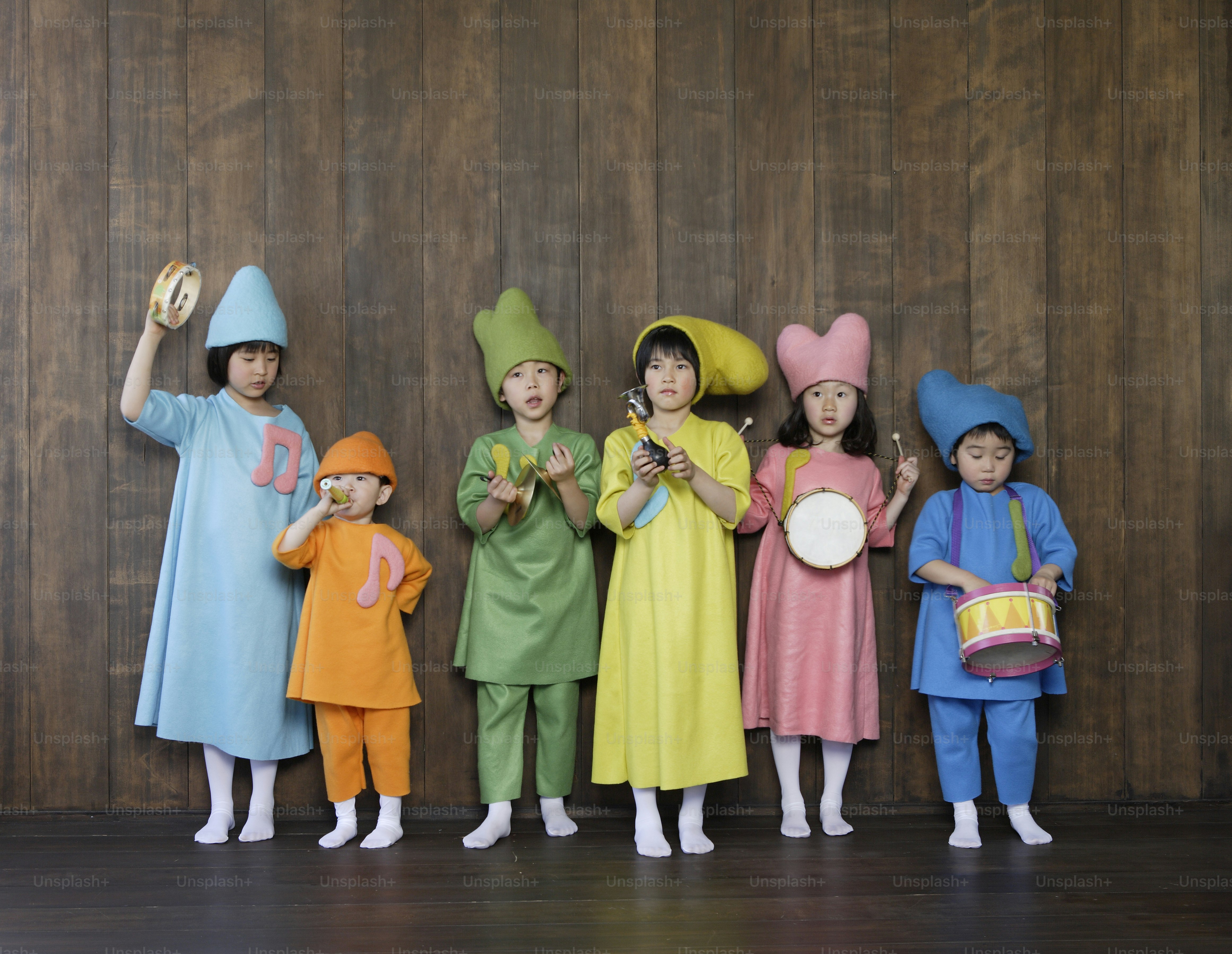 A group of children dressed in costumes standing next to each other ...