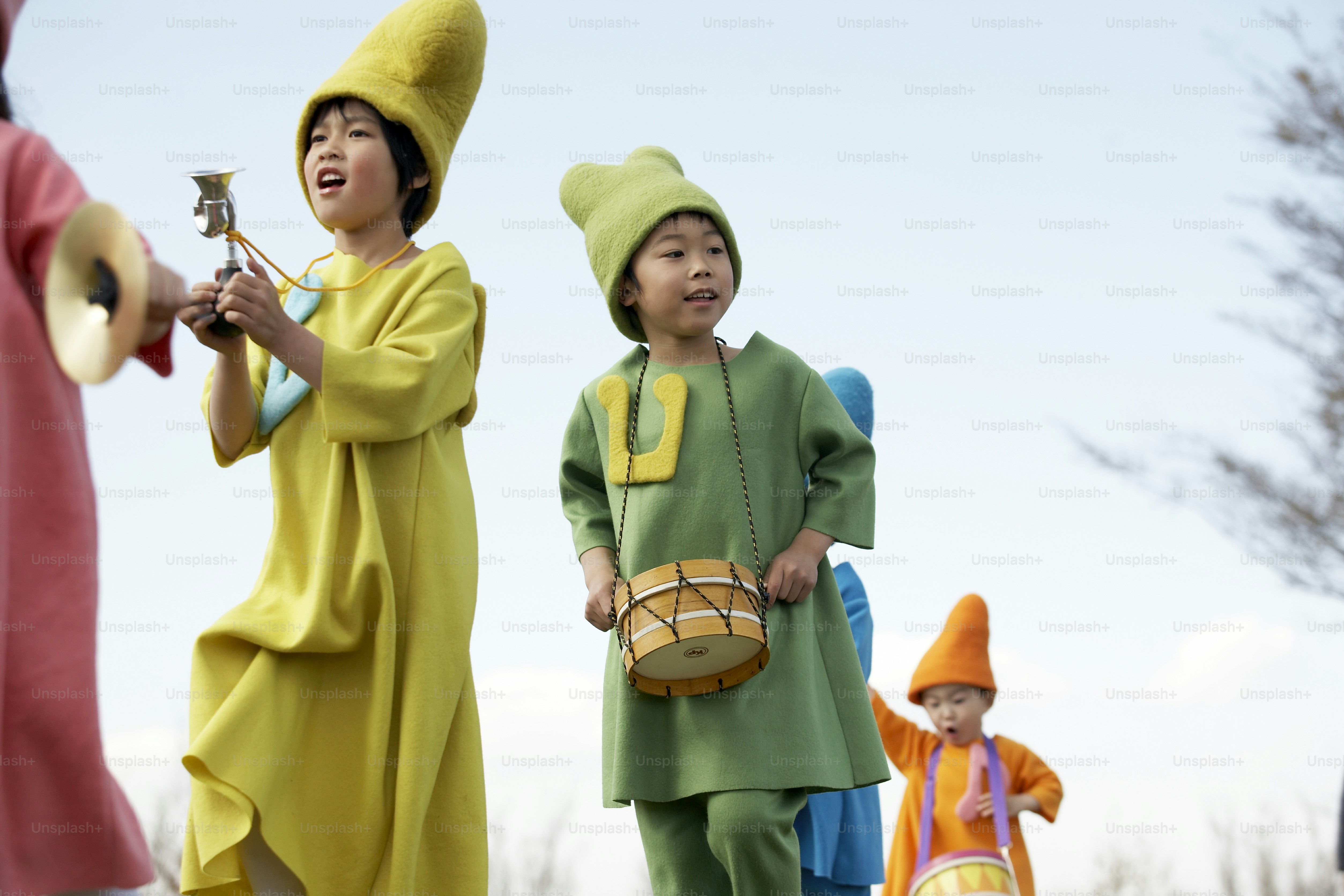 A group of children dressed in costumes playing musical instruments ...