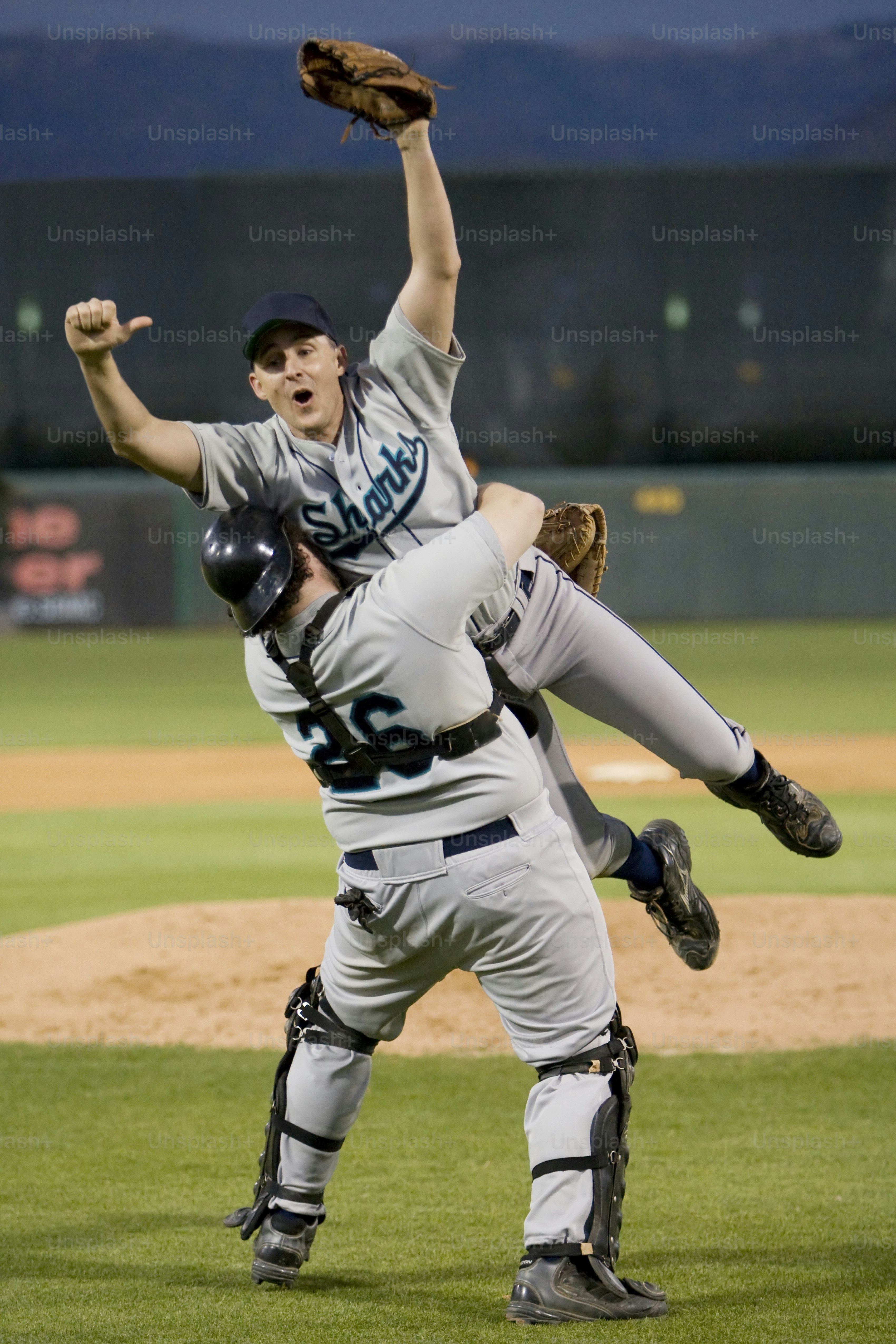 A couple of baseball players standing on top of a field photo ...