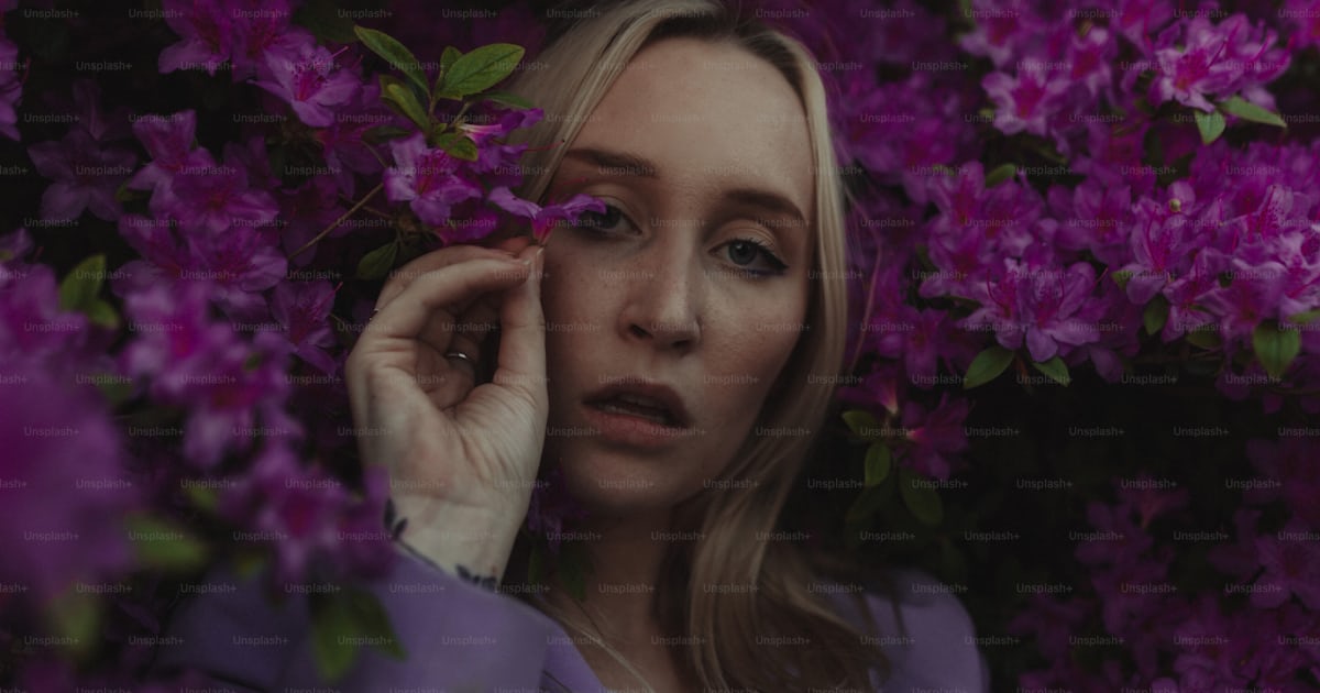 Foto Una Mujer Parada Frente A Un Arbusto De Flores Púrpuras Retrato