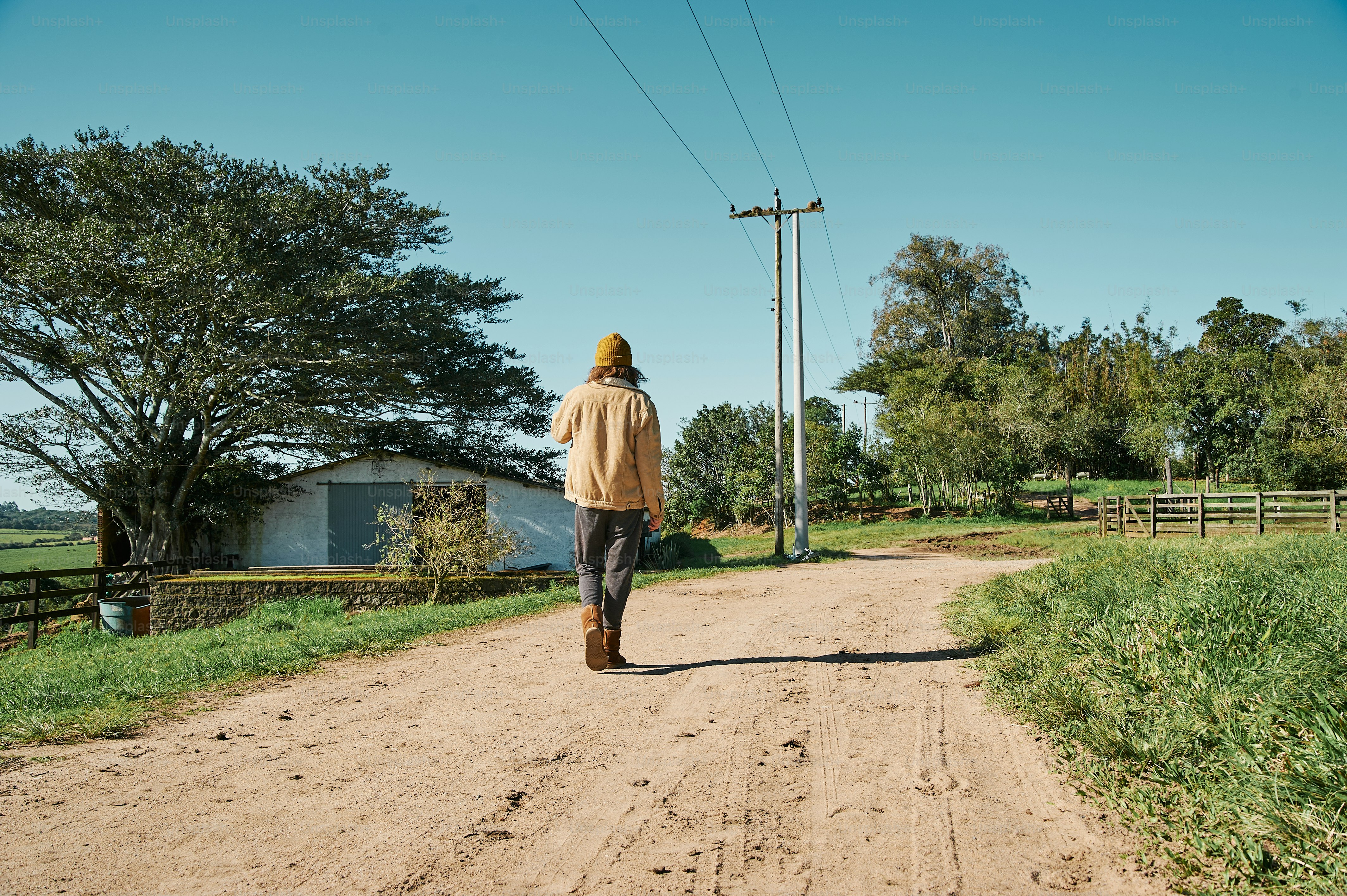 A man walking down a dirt road in the country photo – Sad man walking ...