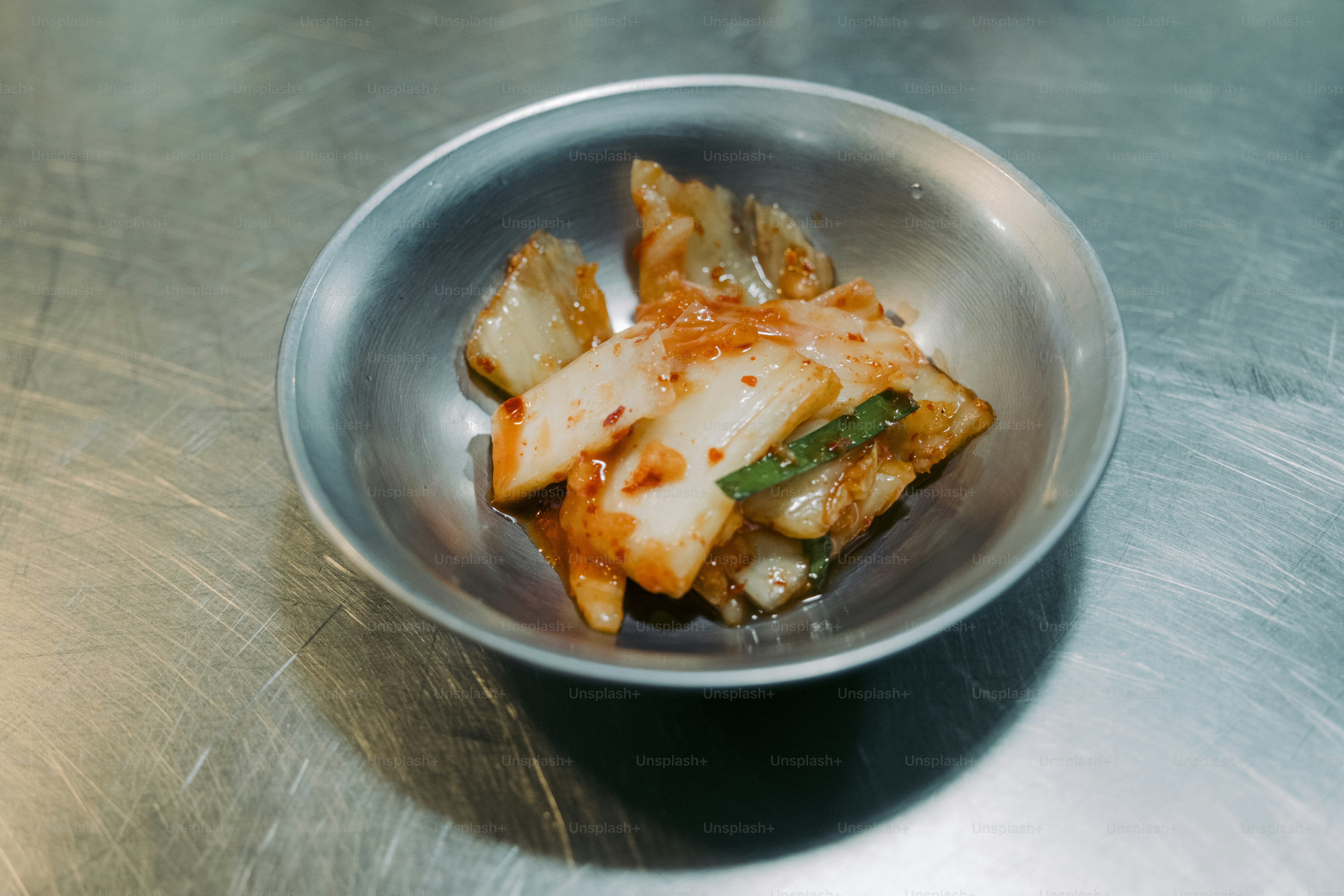 Foto Un tazón de metal lleno de comida encima de una mesa ...