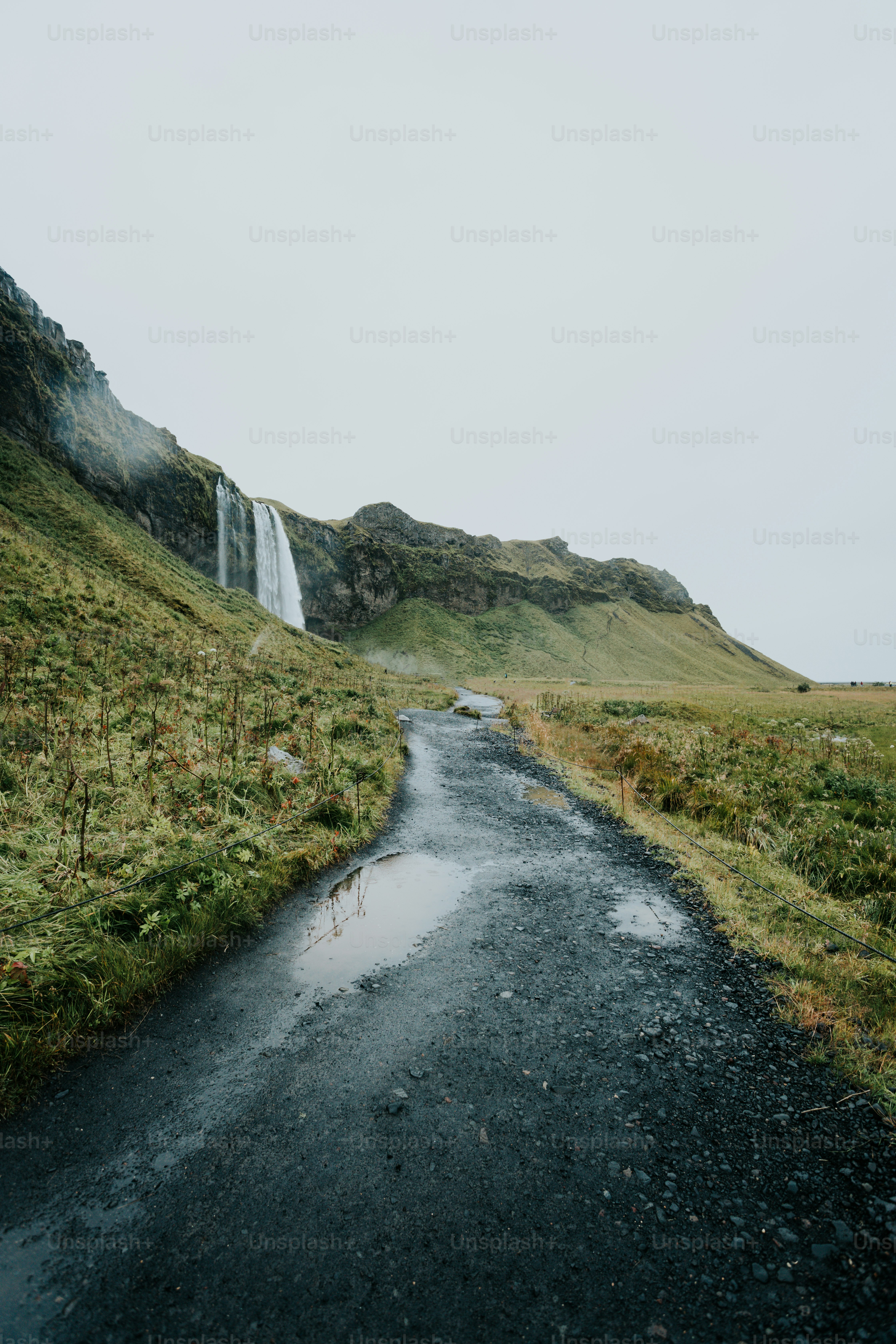 A person driving a car on a road with mountains in the background photo ...