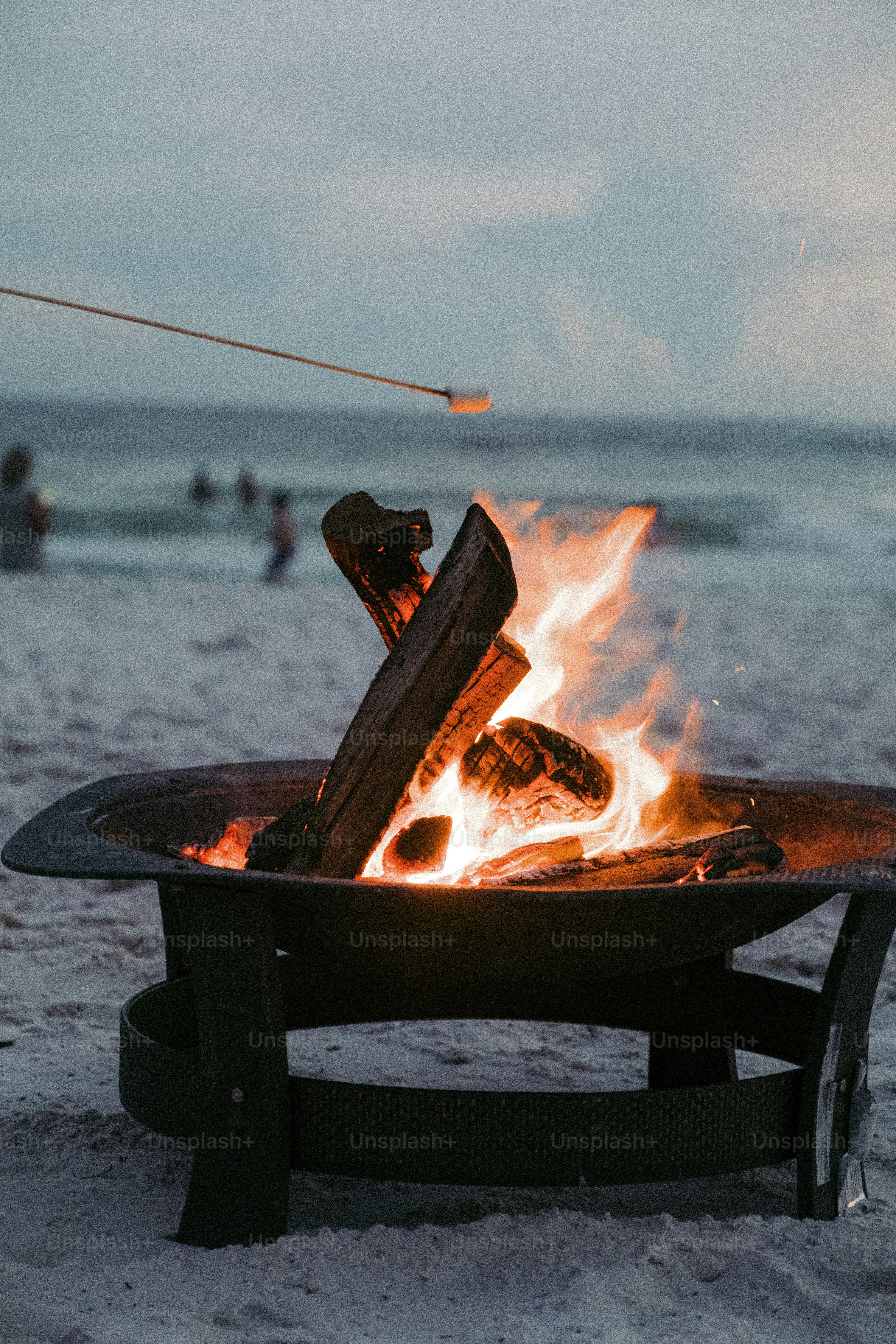A fire pit sitting on top of a sandy beach photo – Survival Image on ...