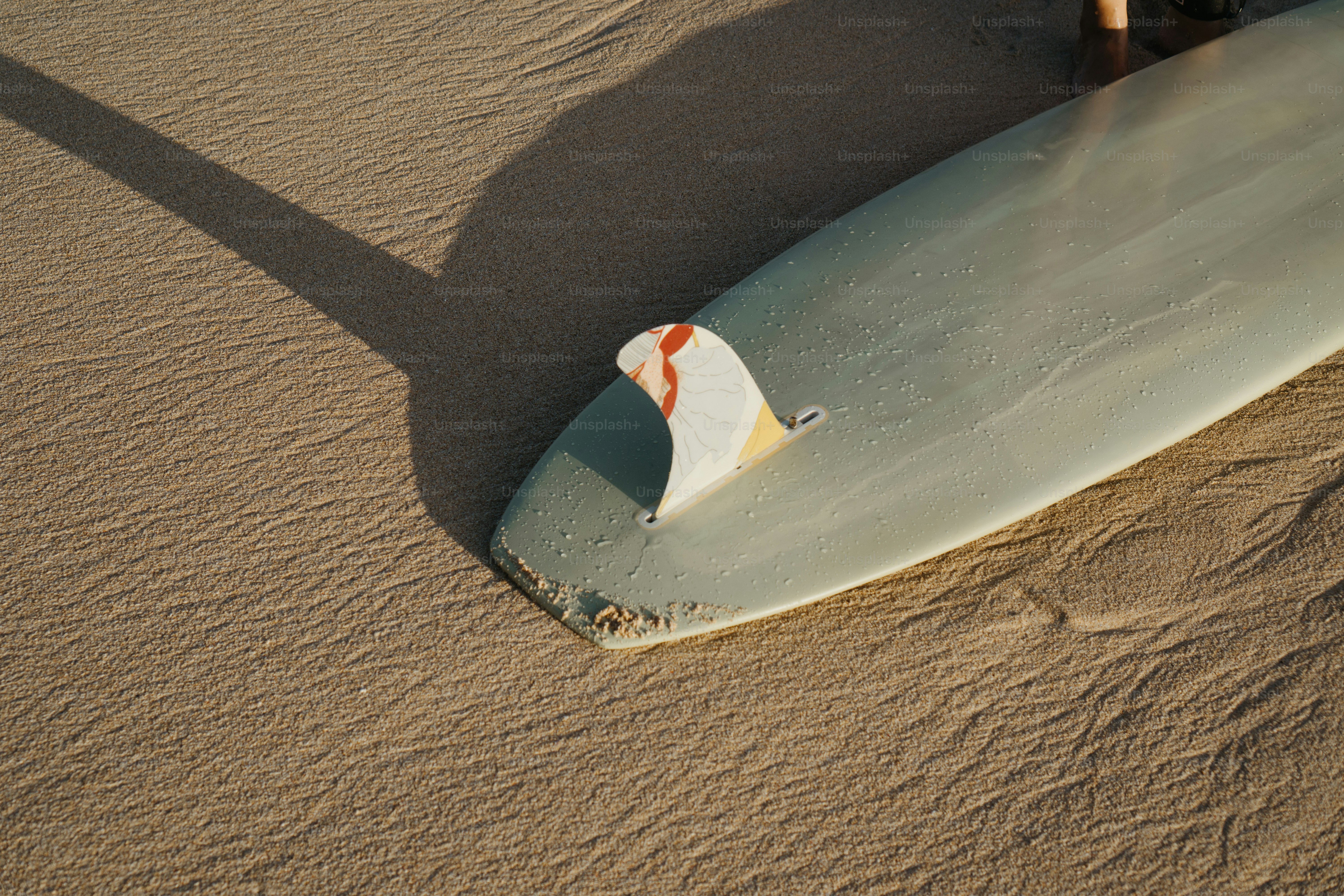 A surfboard laying on top of a sandy beach photo – Texture Image on ...