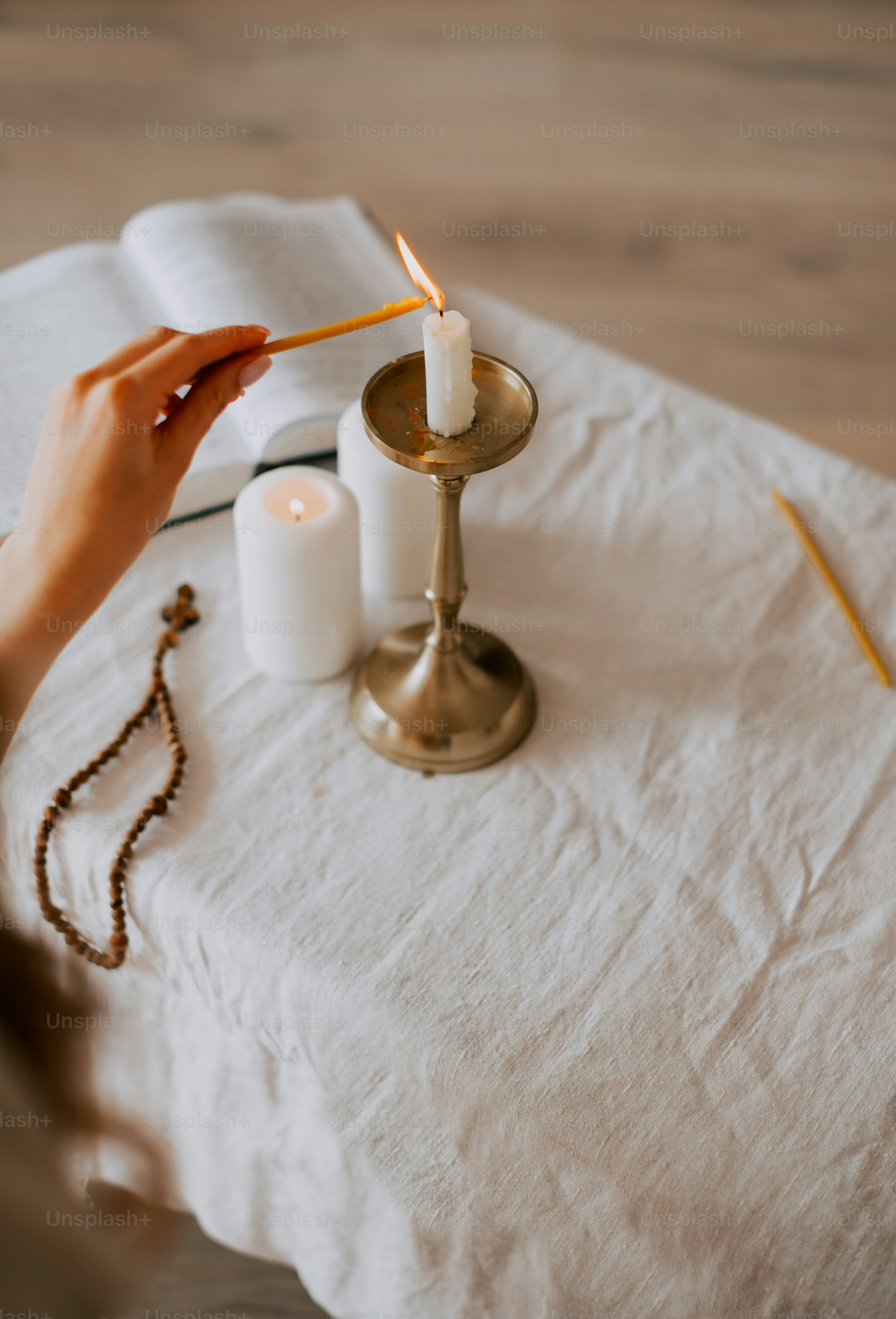 A person lighting a candle on a table photo – Candle Image on Unsplash