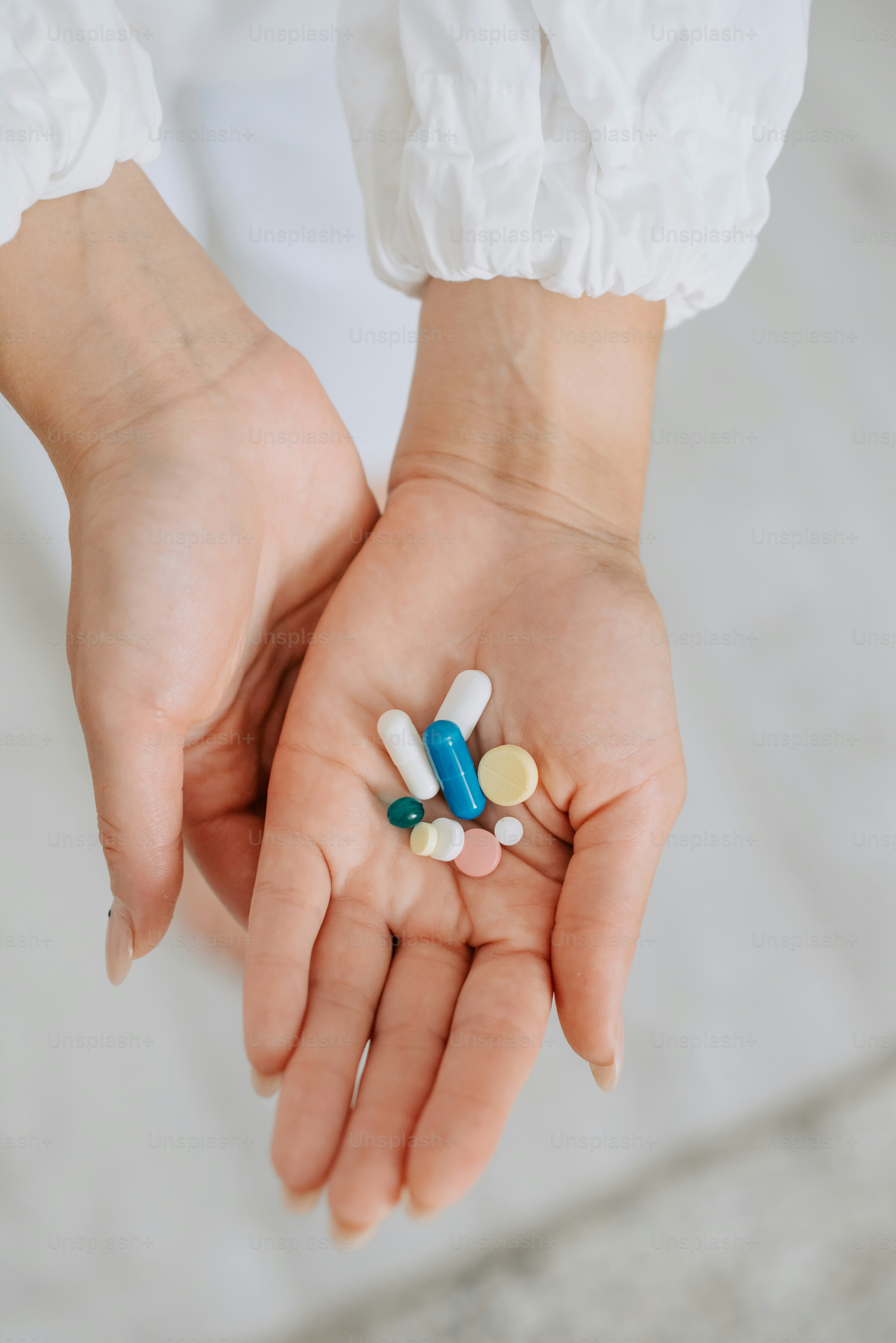 A woman holding a handful of pills in her hands photo – Medication ...