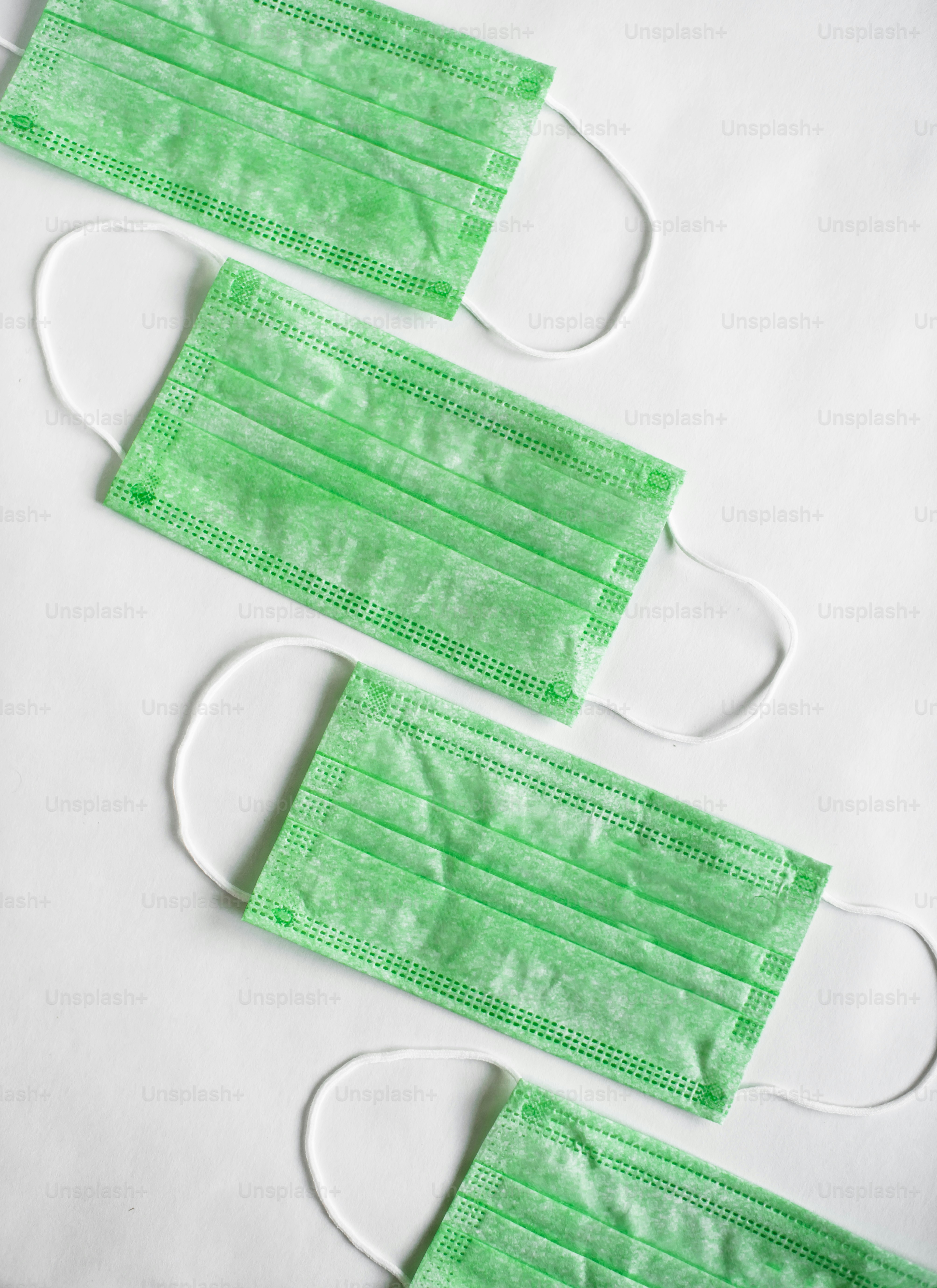 Three green surgical masks on a white background photo – Safety Image ...