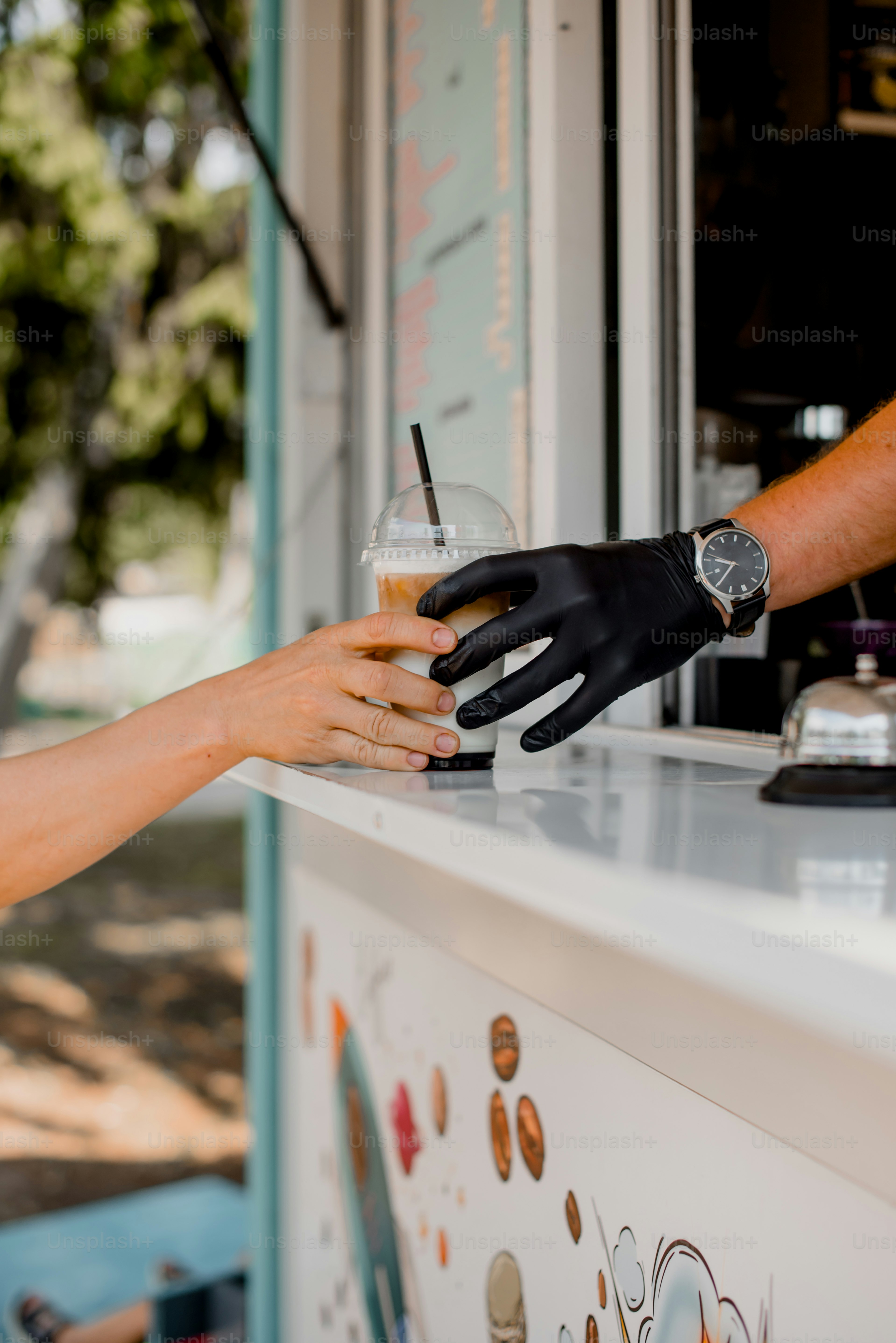 A person handing a drink to another person photo – Ice coffee Image on ...