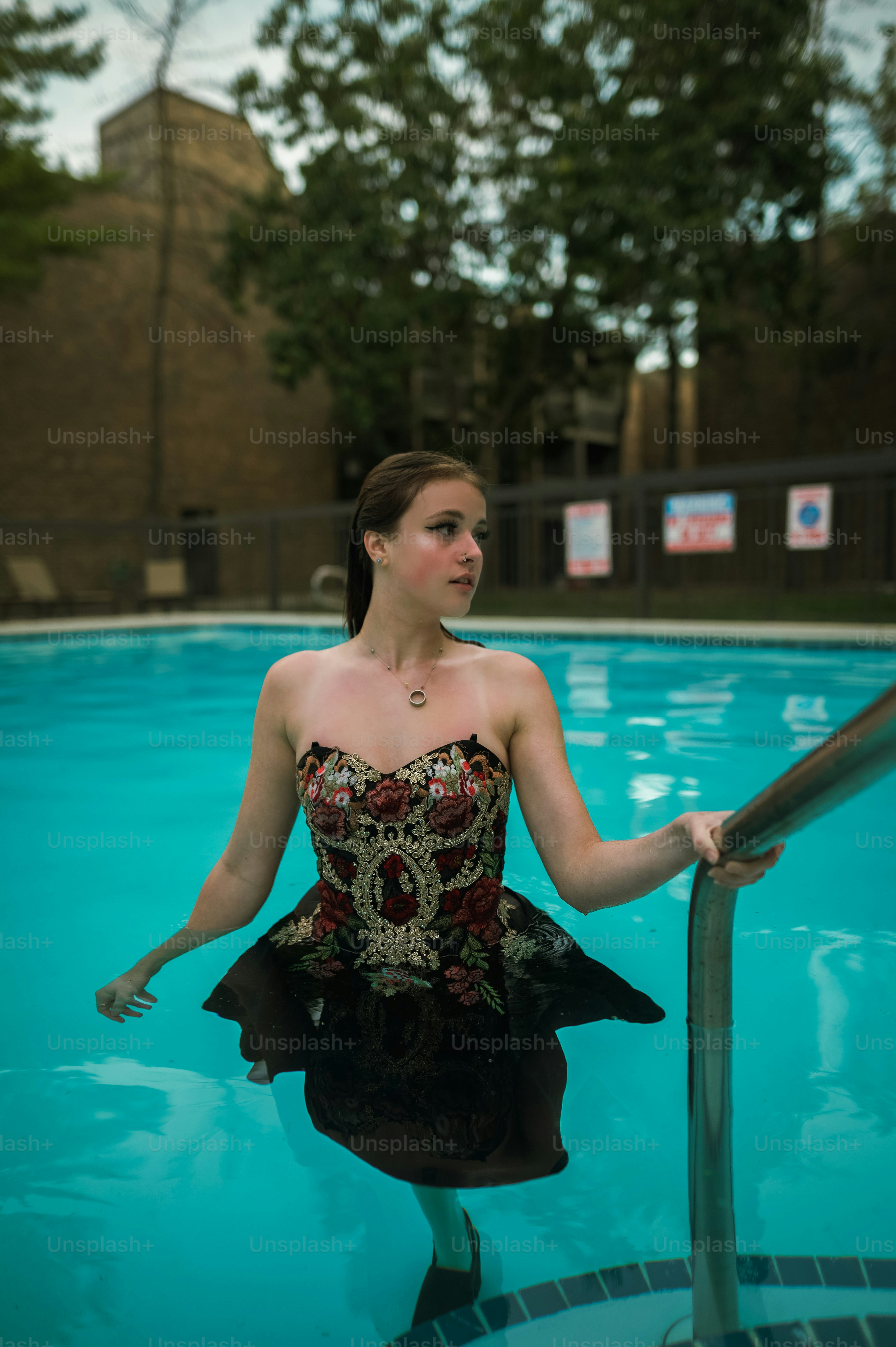 Foto zum Thema Eine frau in einem kleid, die in einem pool steht – Bild ...