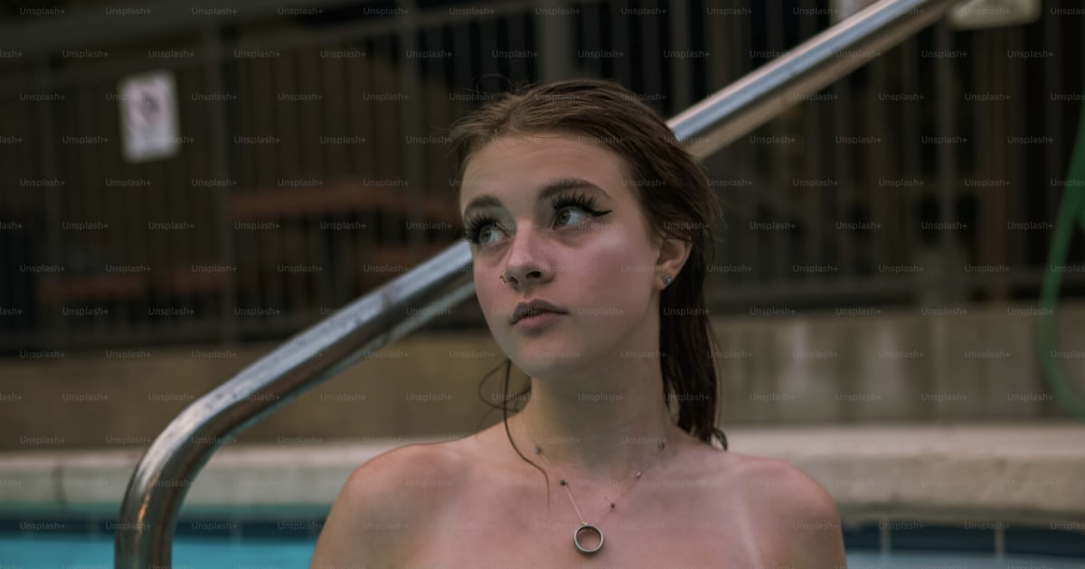 Une Femme Assise Dans Une Piscine Avec Sa Main Sur Le Bord De La Piscine Photo Femme Photo Sur
