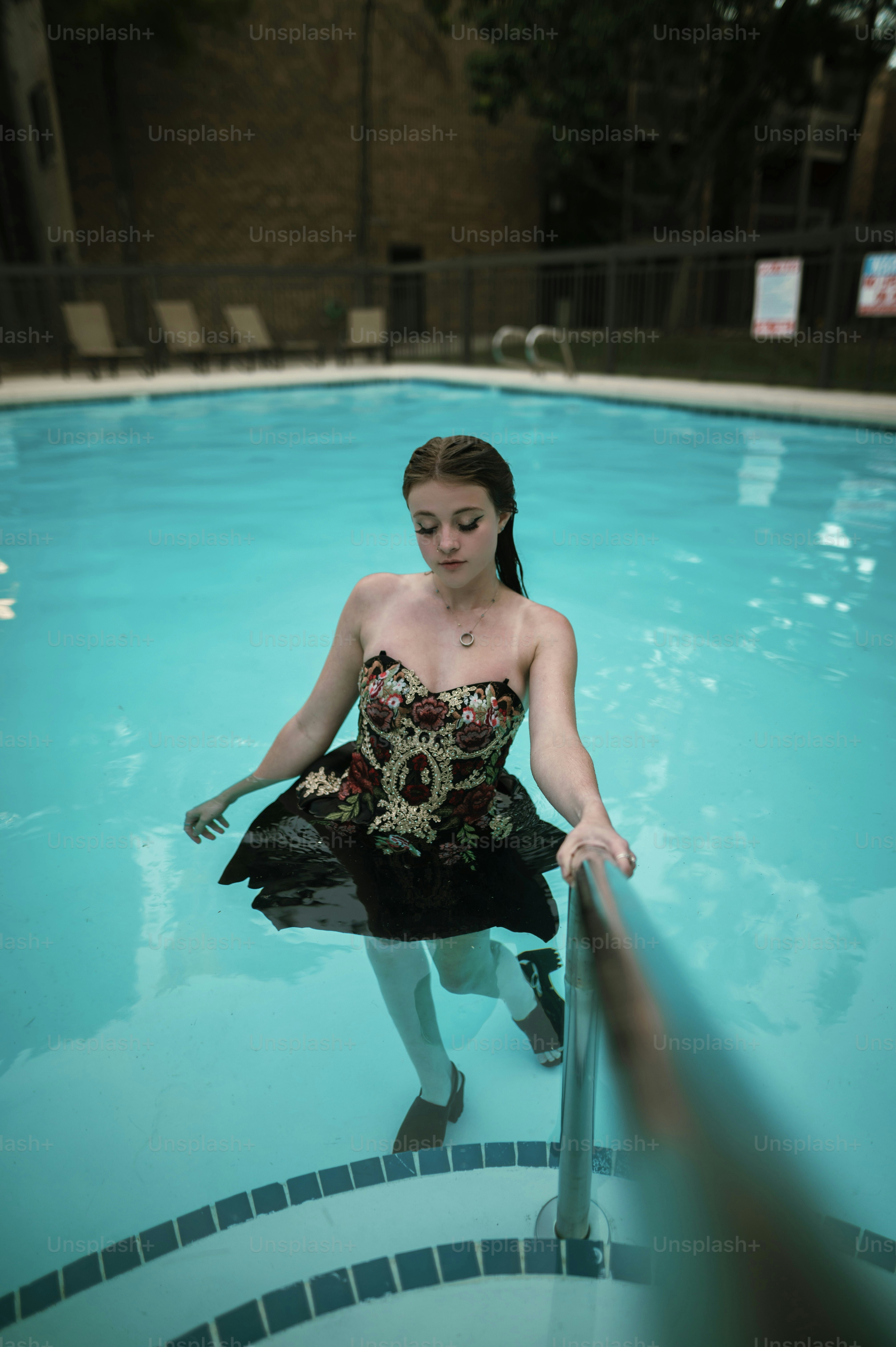 A woman in a dress is standing in a pool photo – Woman Image on Unsplash