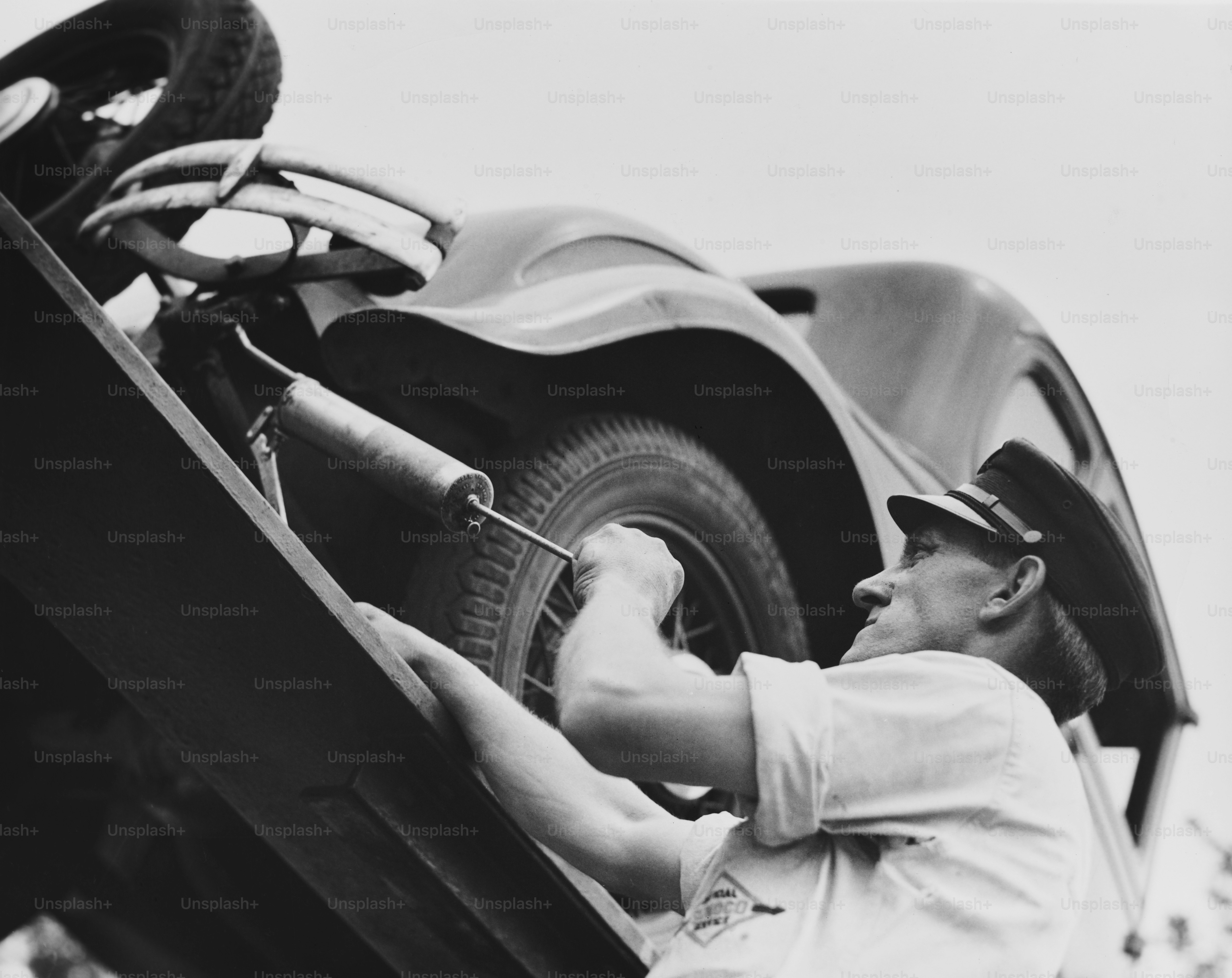 A mechanic servicing a car, circa 1950. (Photo by George Marks ...