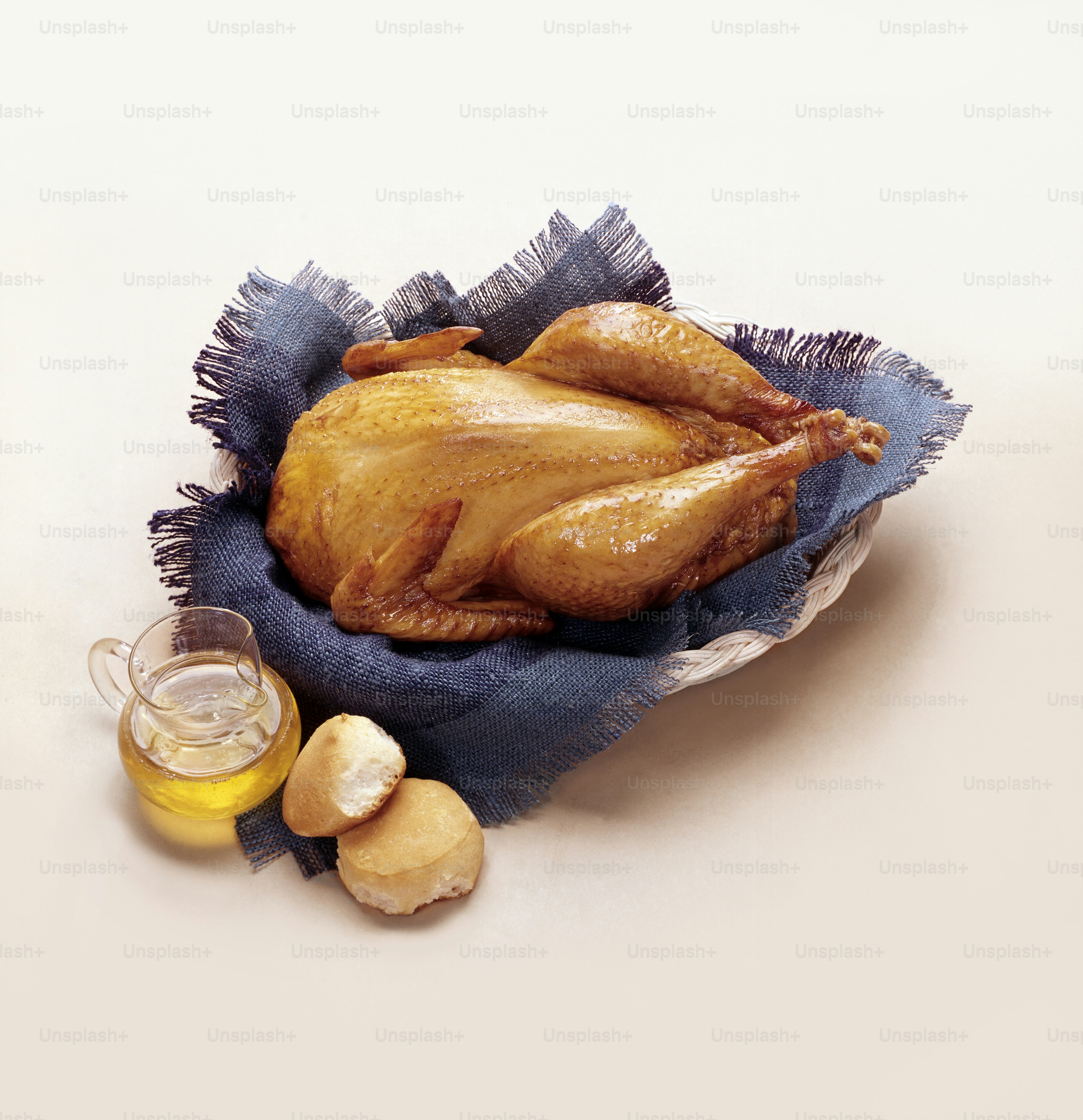 View of a cooken chicken in basket with a small pitcher of honey & and ...