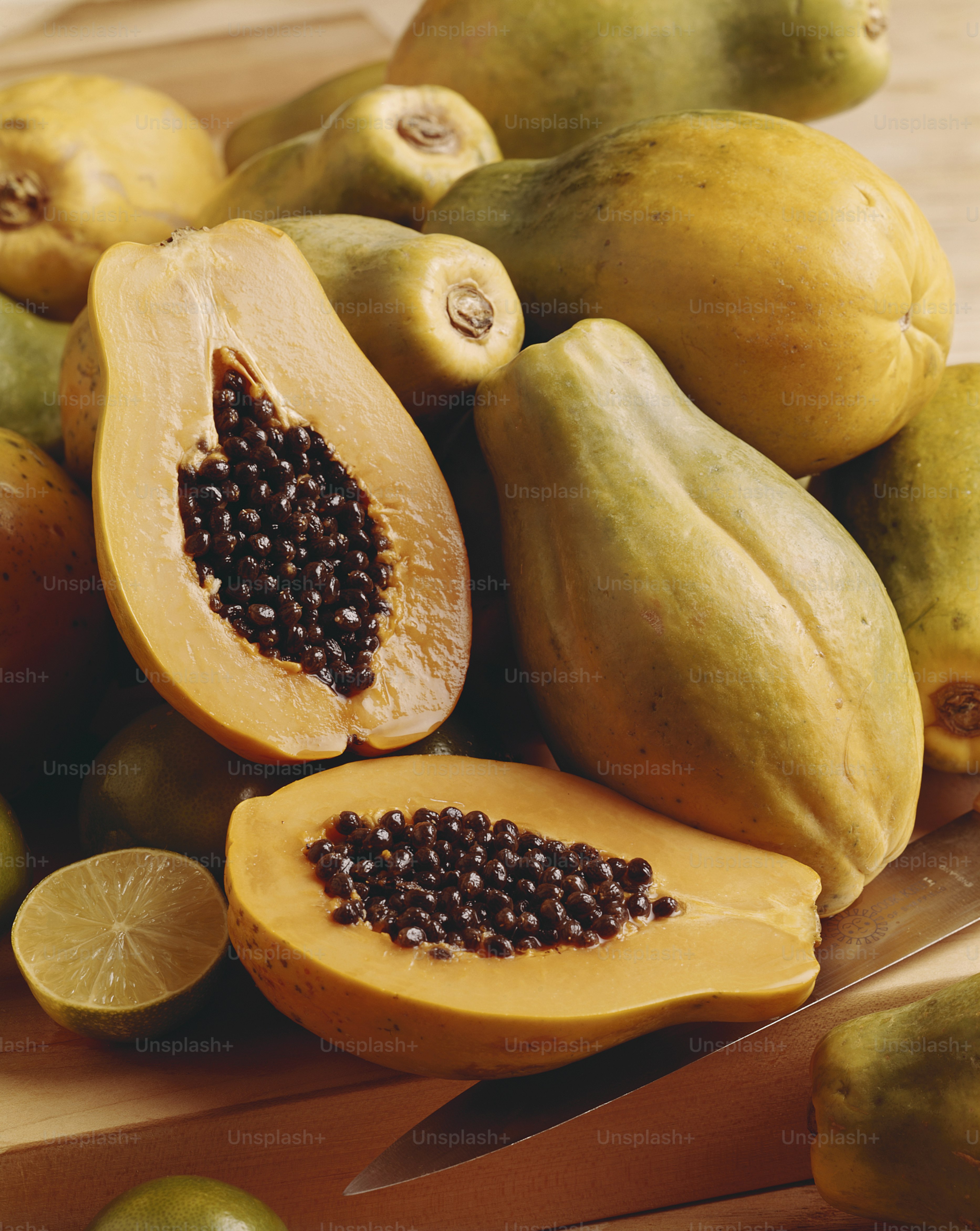 A pile of fruit sitting on top of a wooden cutting board photo – Papaya ...