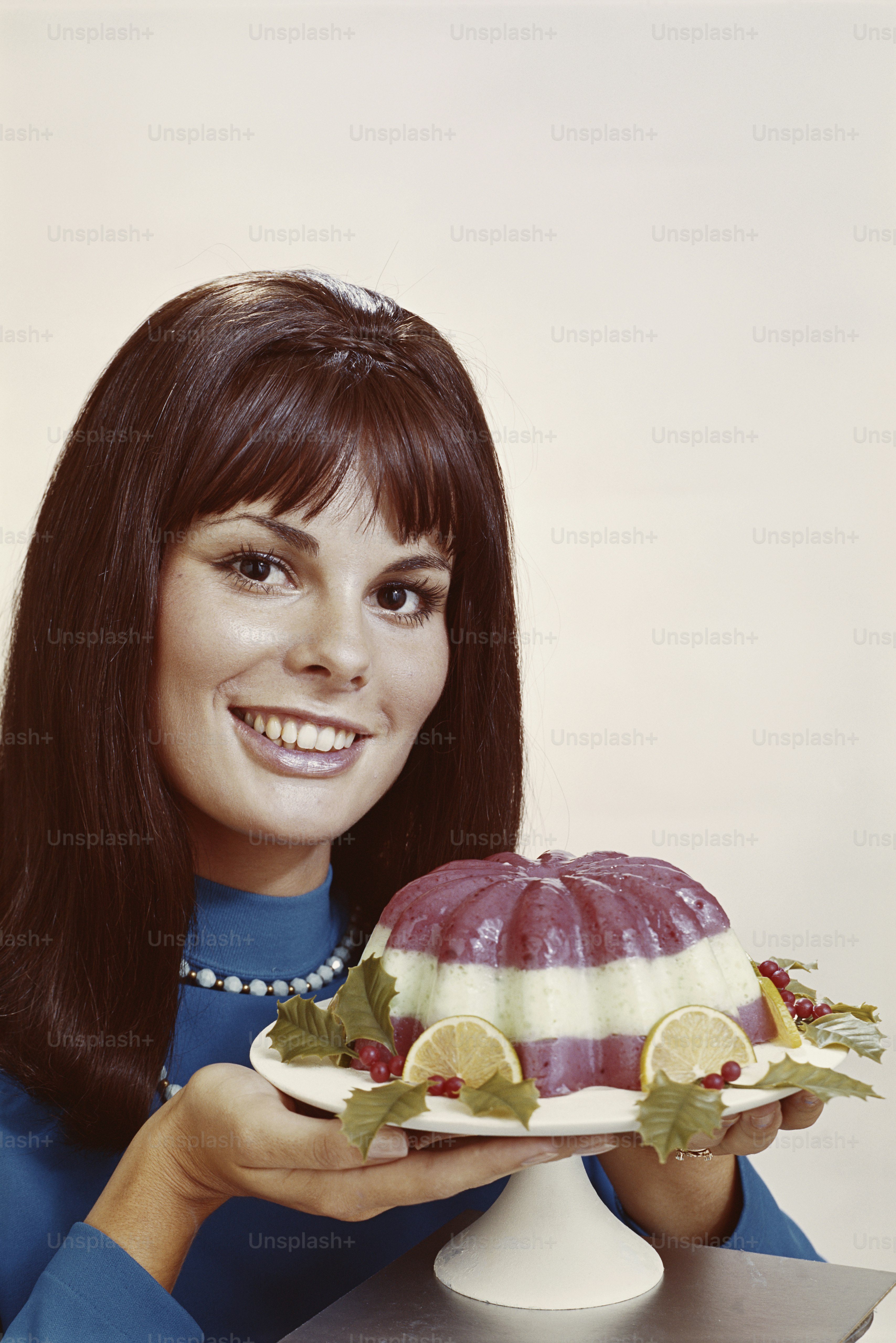 A woman holding a plate with a cake on it photo – Bangs - hair Image on ...
