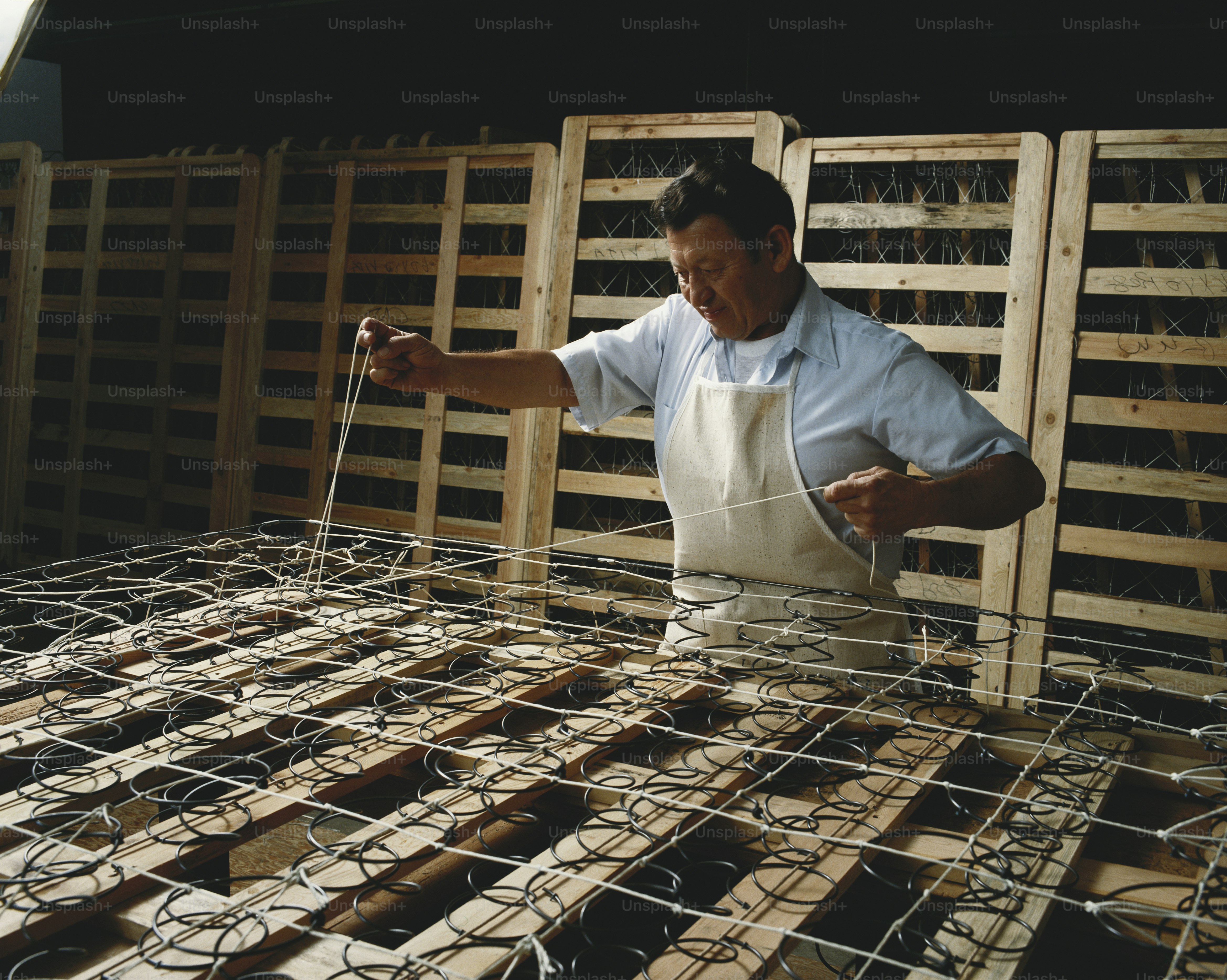 A man in an apron is working on a cage photo – Industry Image on Unsplash