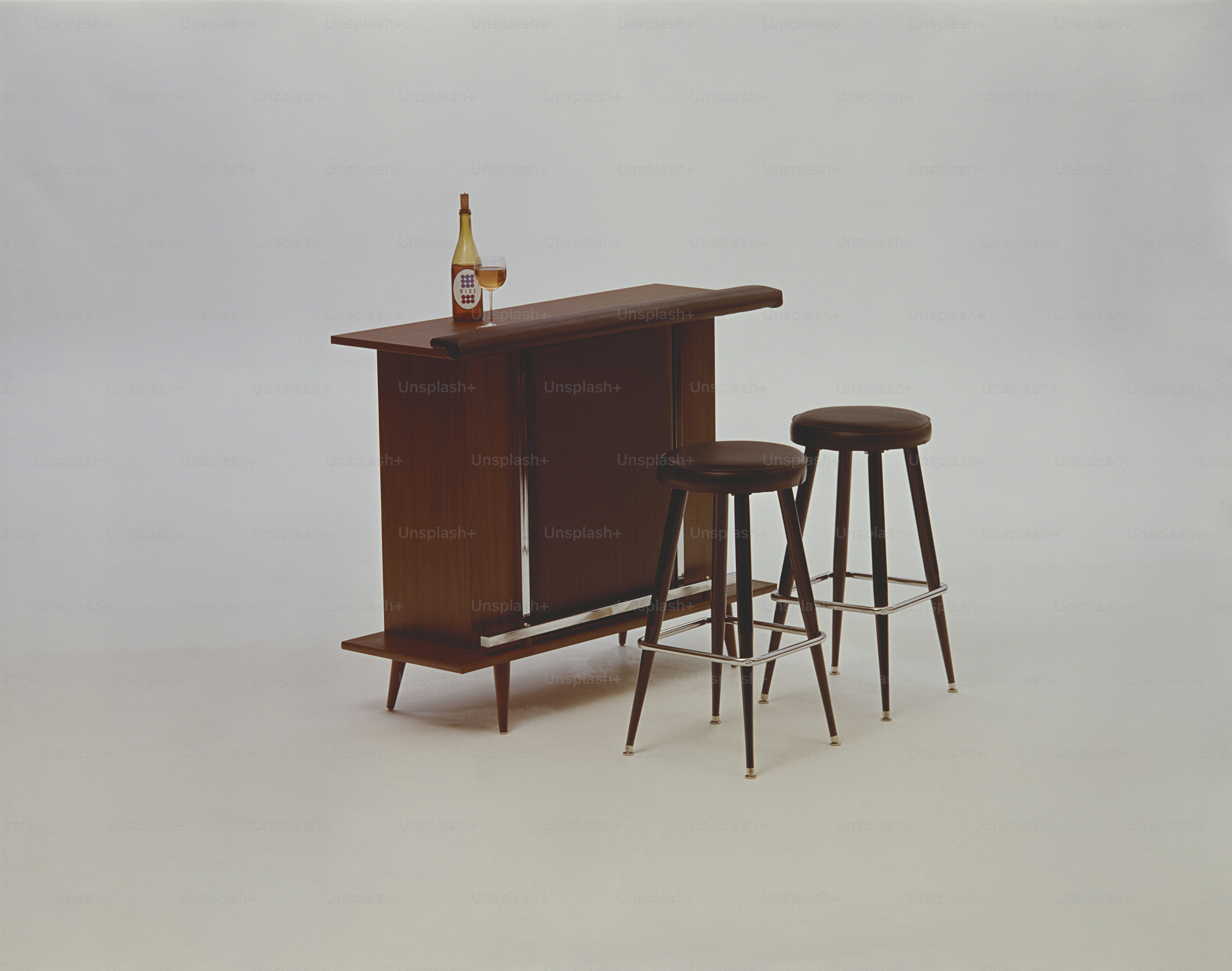 A bar with three stools and a bottle of beer photo – Beer glass Image ...