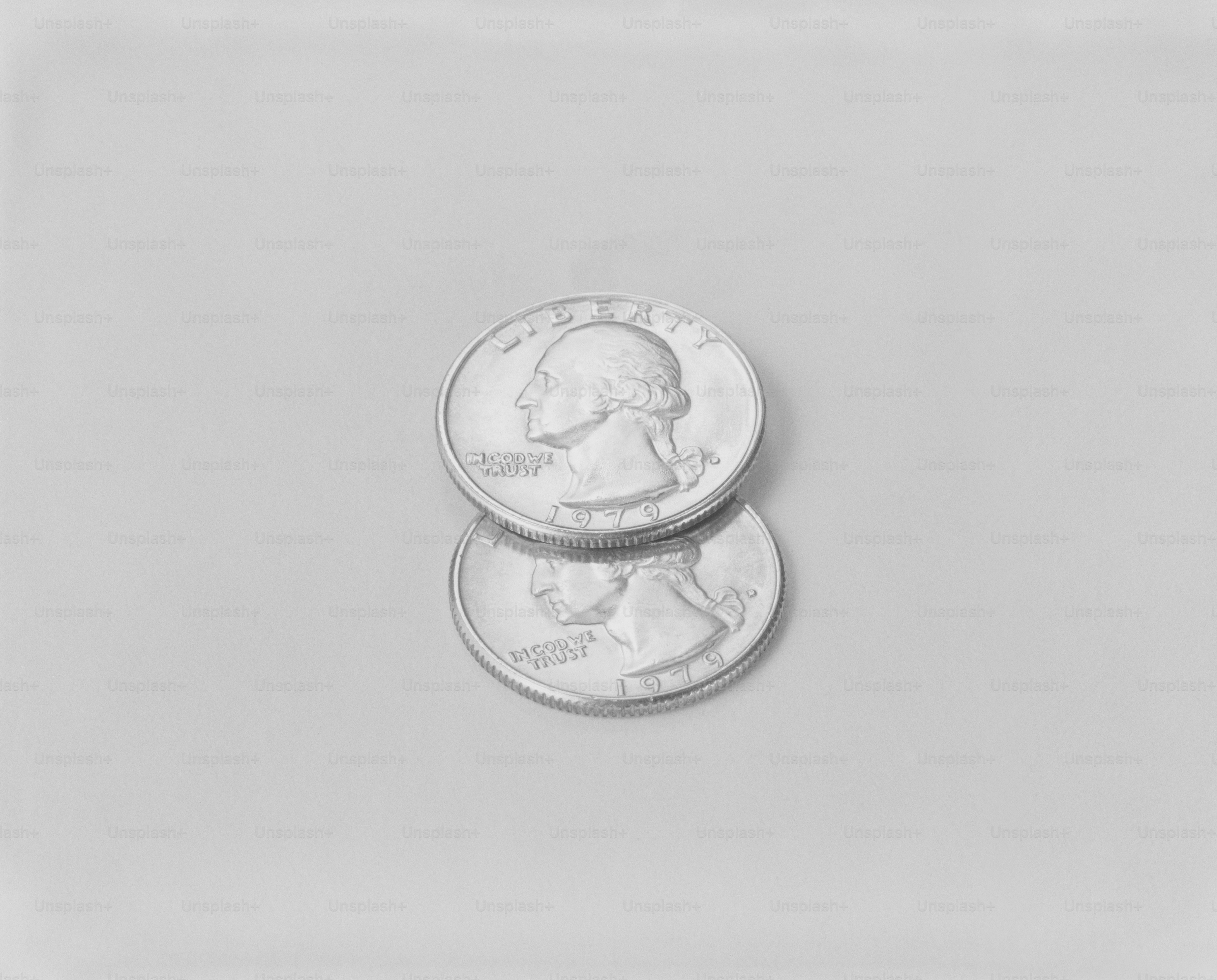 A couple of quarters sitting on top of a table photo – Two objects ...