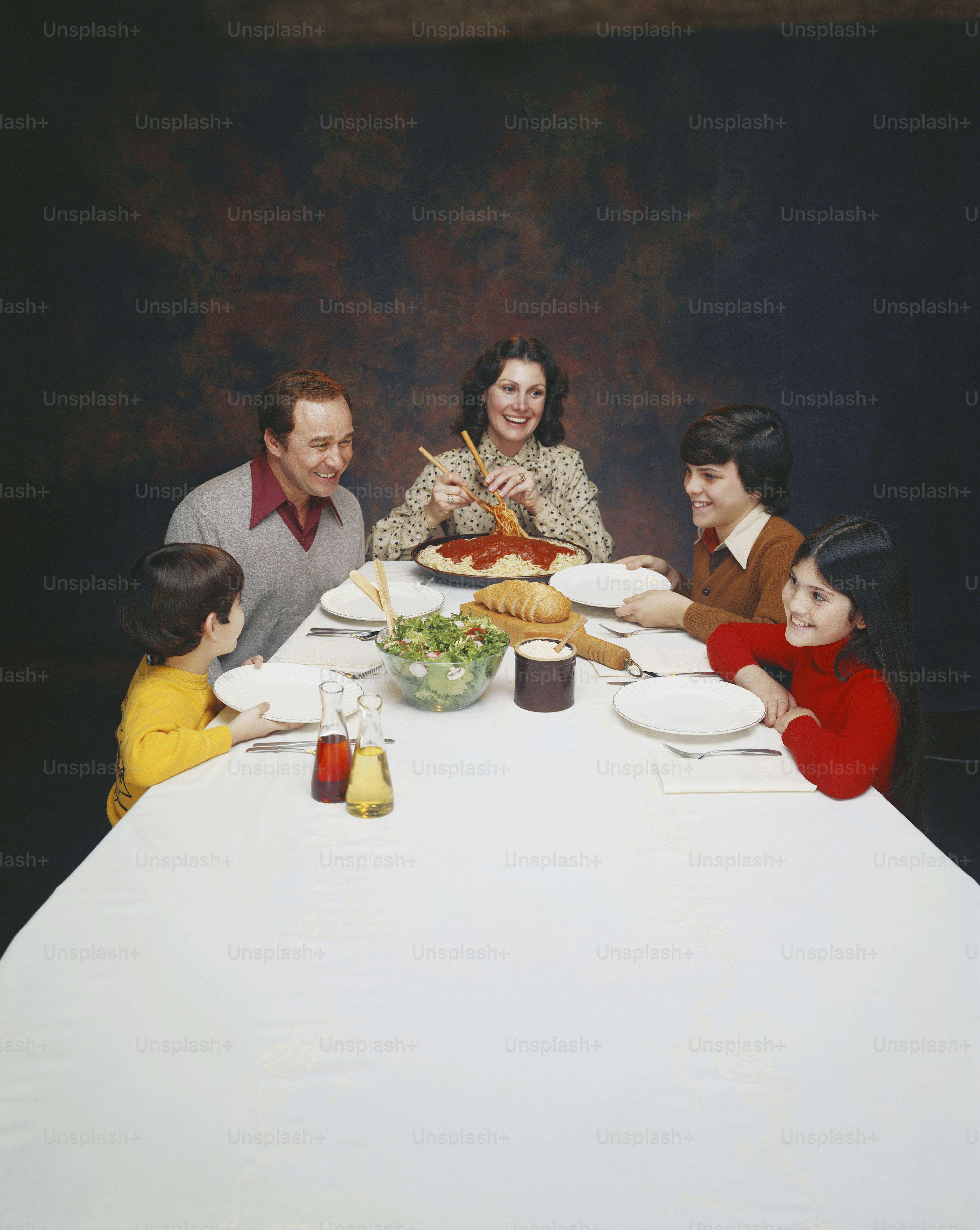 A group of people sitting around a white table photo – Adult Image on ...