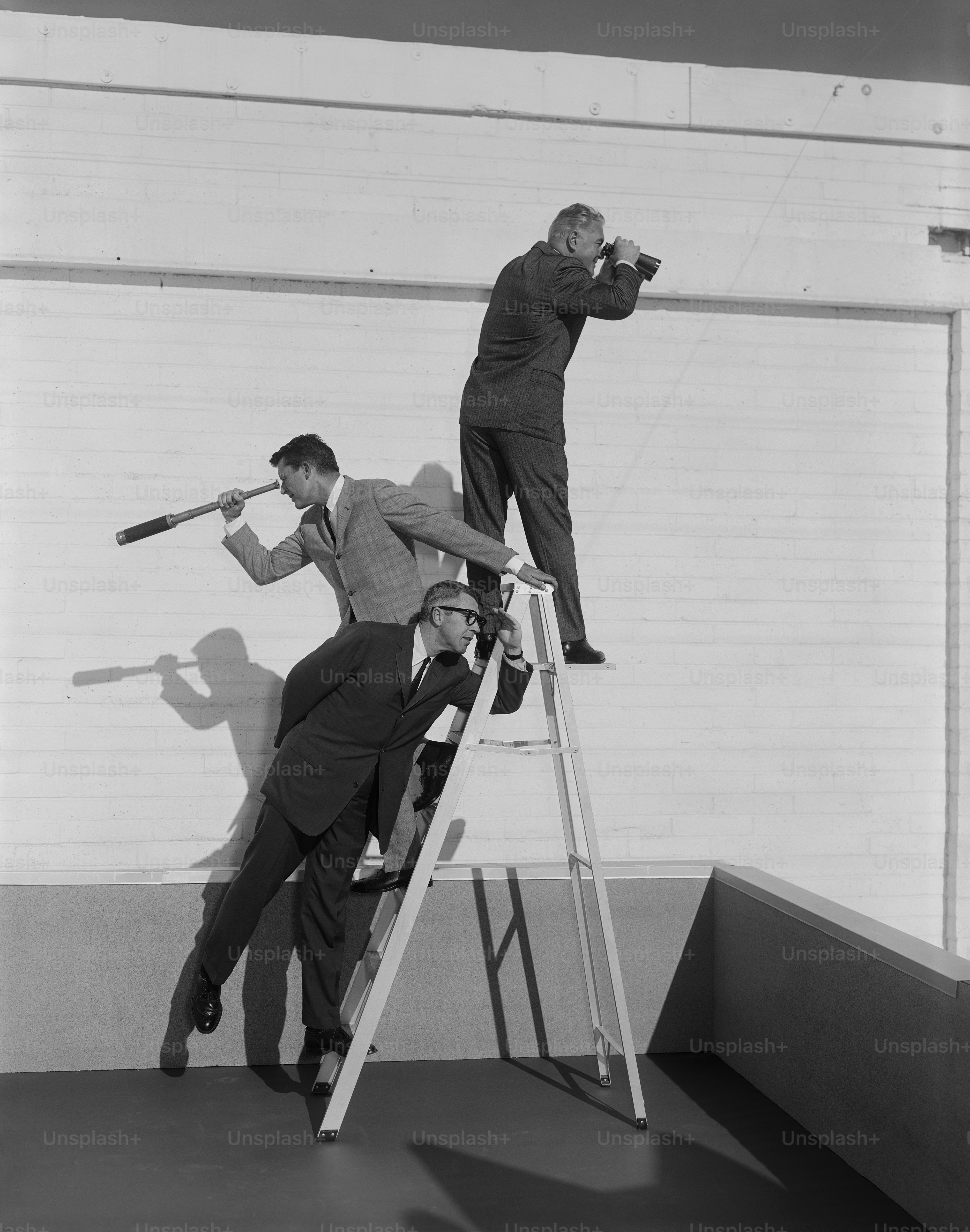 A black and white photo of two men on a ladder photo – Ladder Image on ...