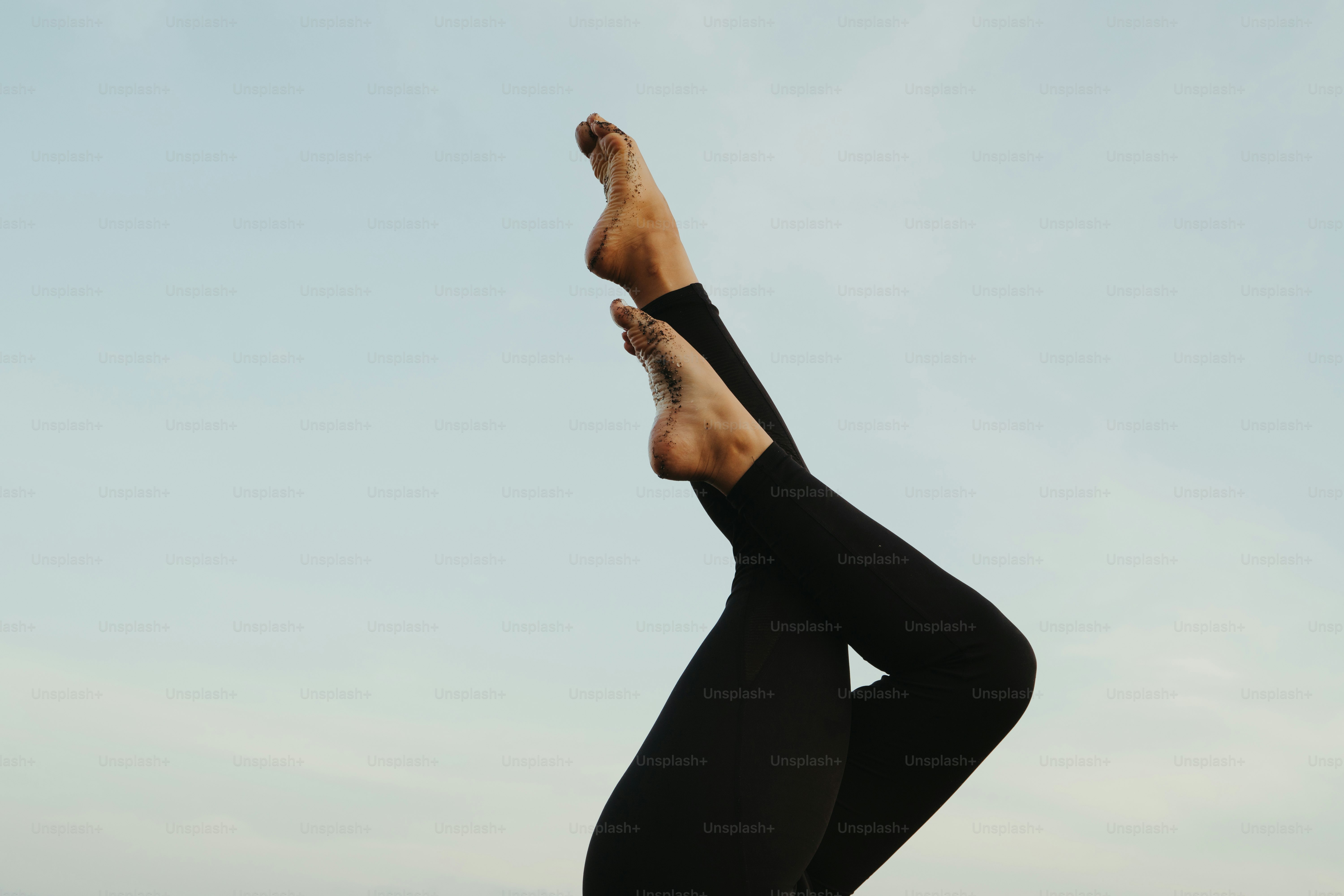 A person doing a yoga pose on a beach photo – Legs Image on Unsplash