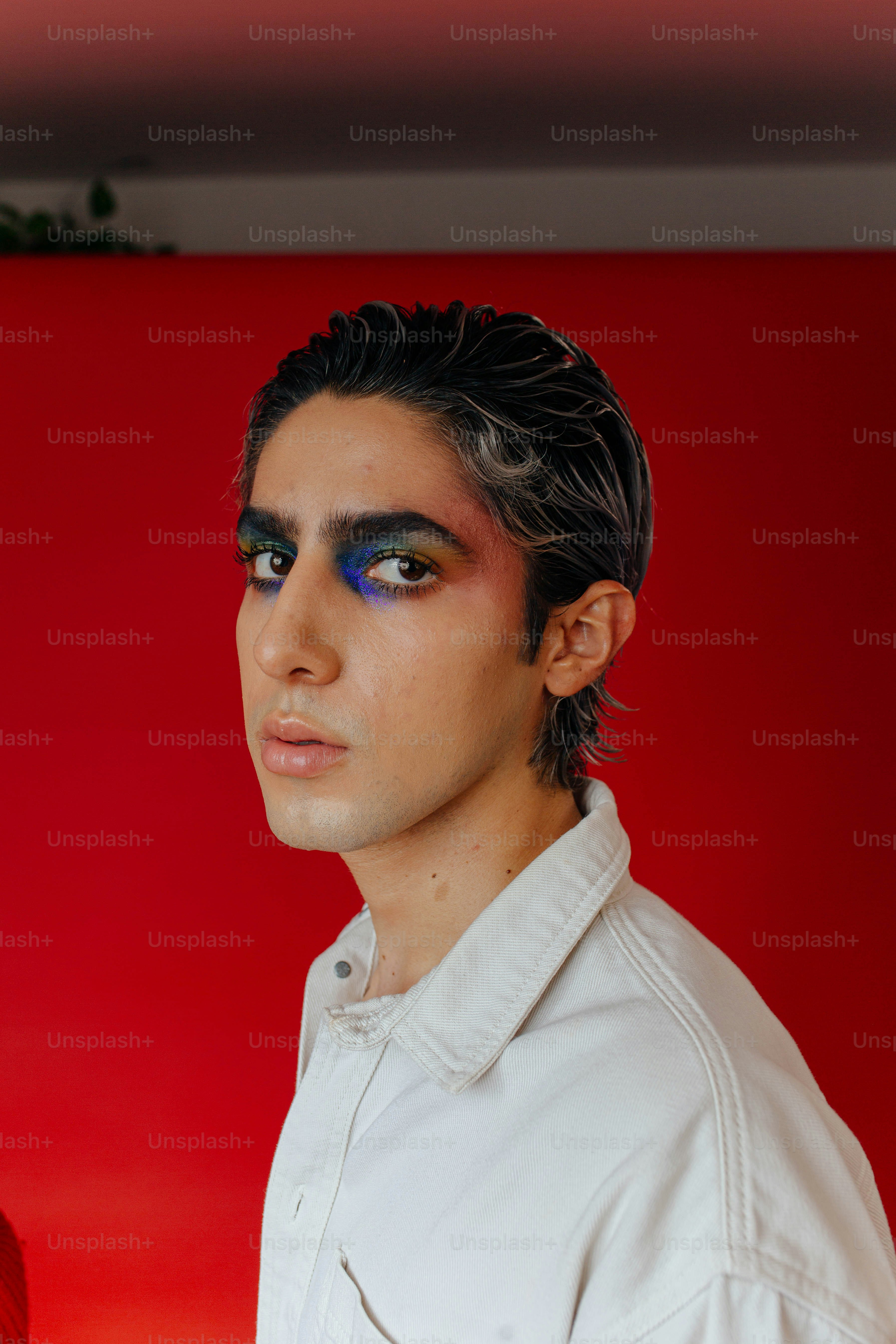 A man with black and blue makeup on his face photo – Eyeshadow Image on ...