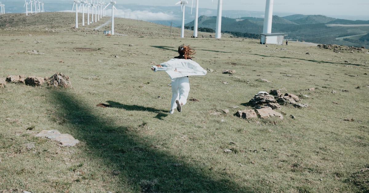 Foto Zum Thema Eine Person Auf Einem Feld Mit Windkraftanlagen Im