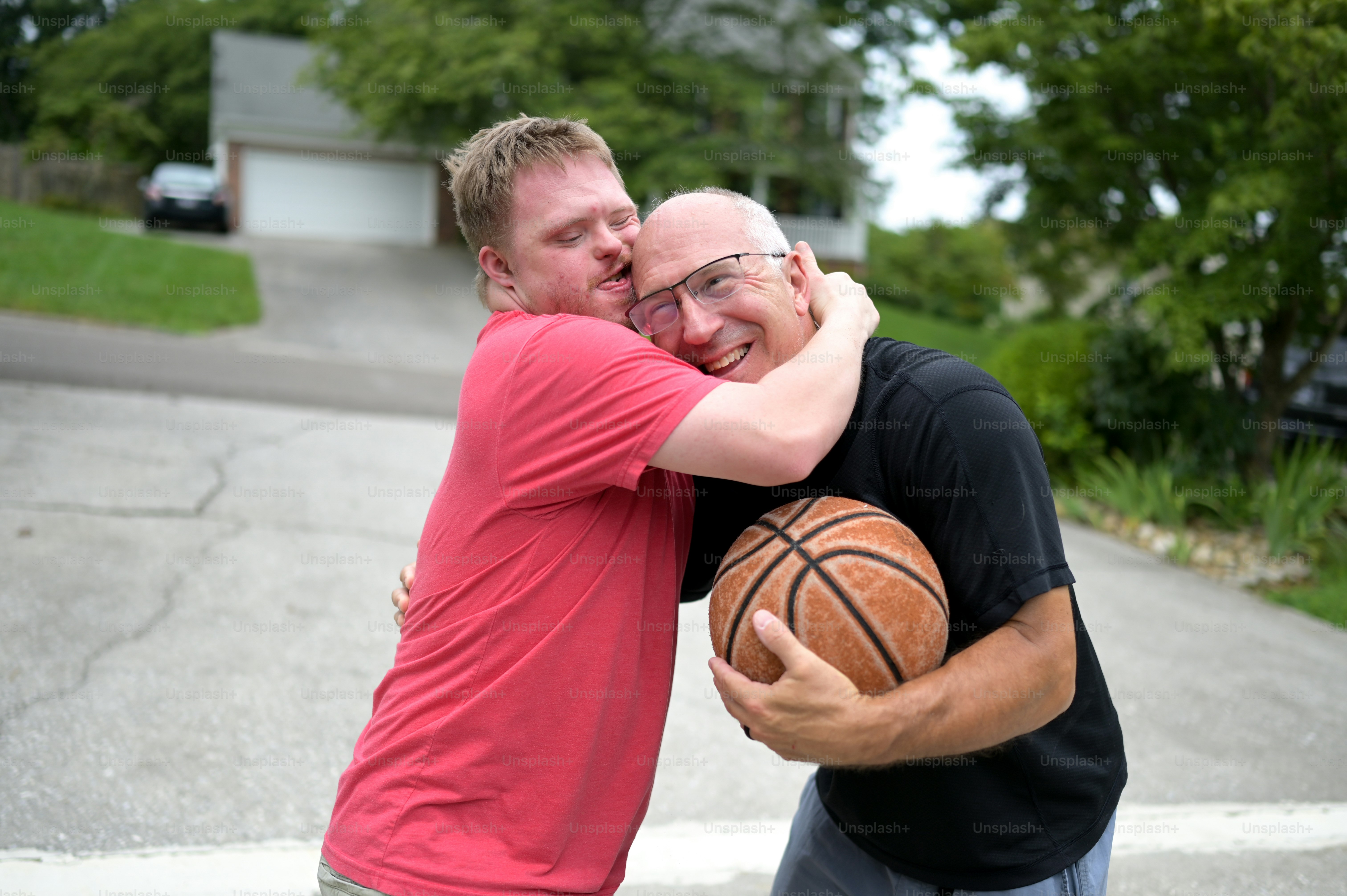 Two men hugging each other while holding a basketball photo – Hugging ...