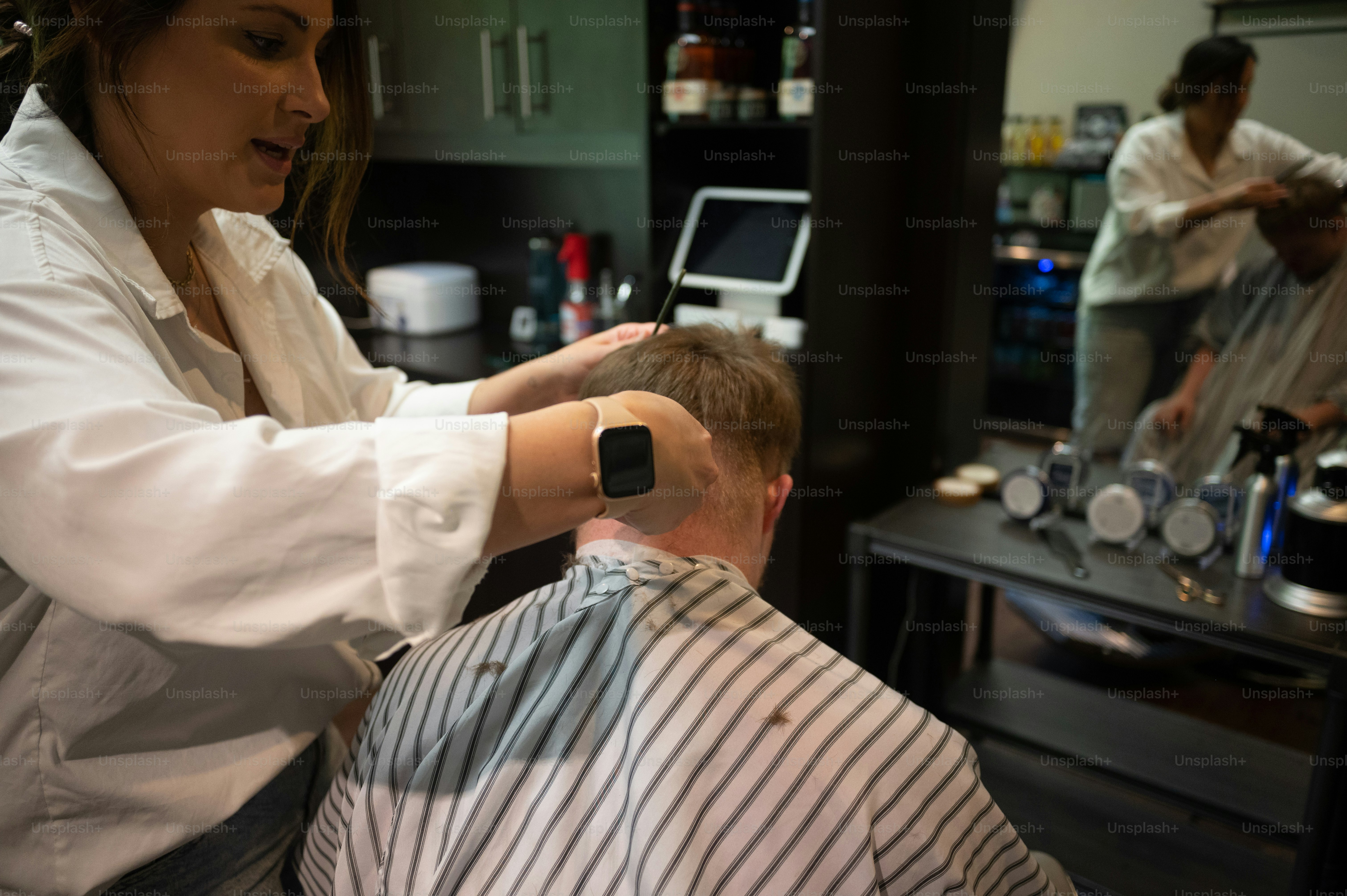 A woman cutting a mans hair in a barber shop photo – Hairdresser Image ...